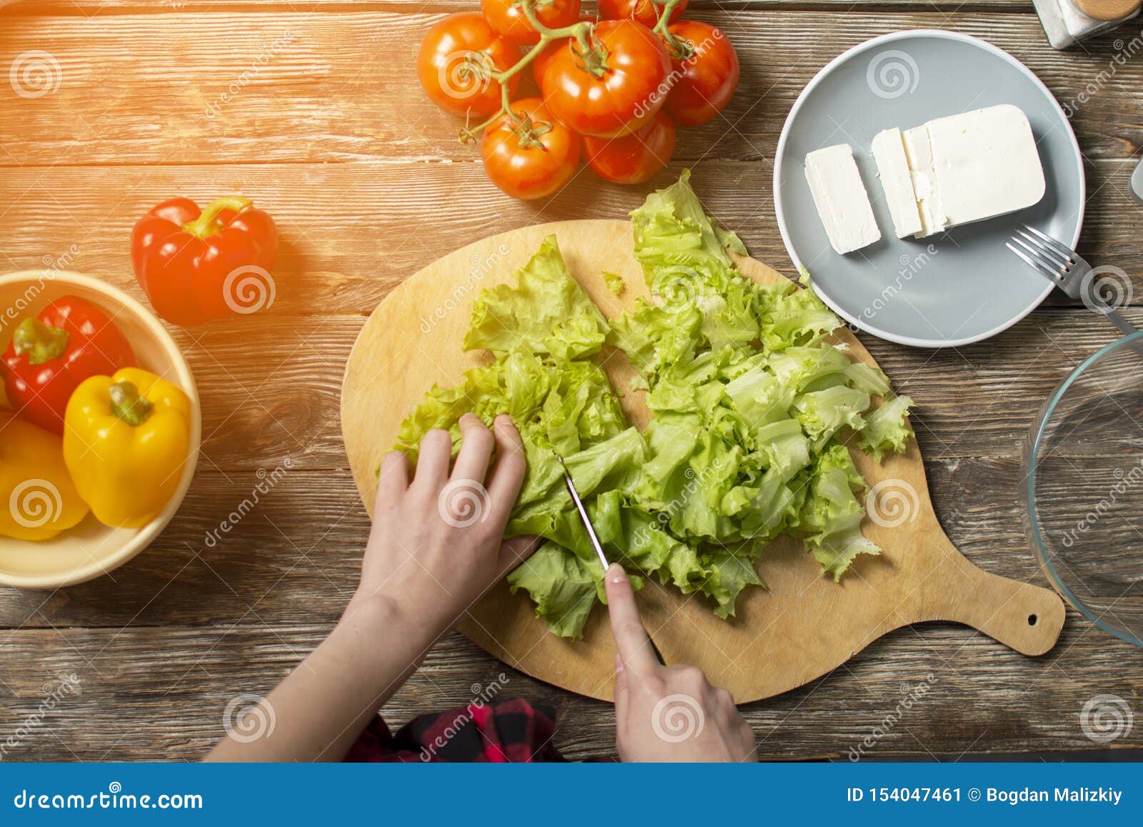 Hands Of The Girl Cut Lettuce On A Table A Woman Prepares A Veggie