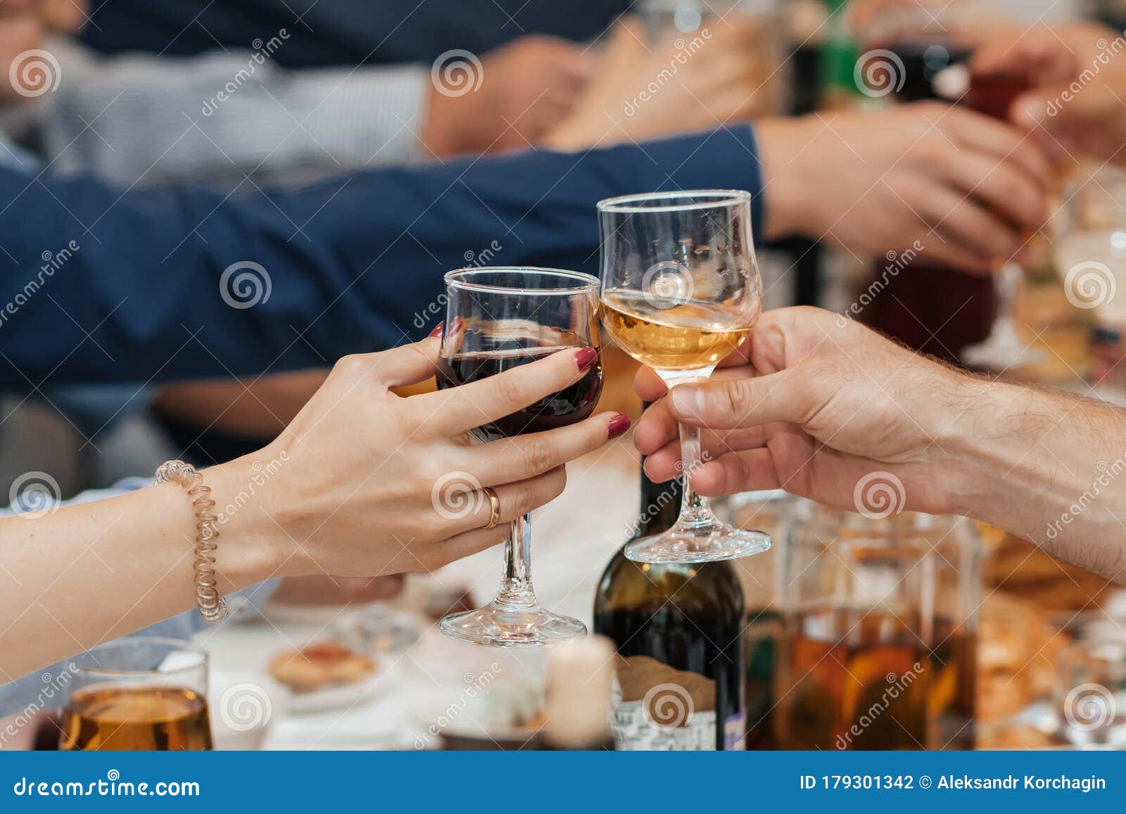 Hands Of A Group Of Friends Clinking Glasses Of Wine And Toasting Stock