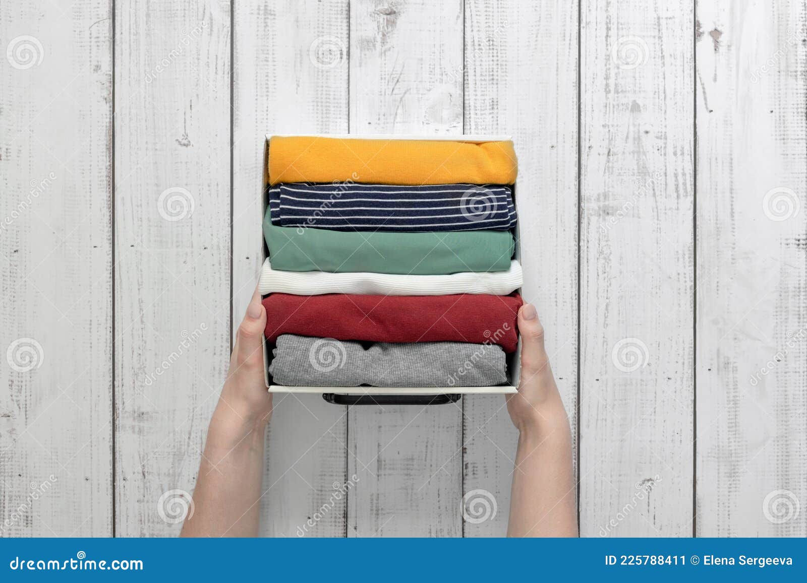 Hands Hold A Container With Neatly Folded Clothes, Storage Of Things ...