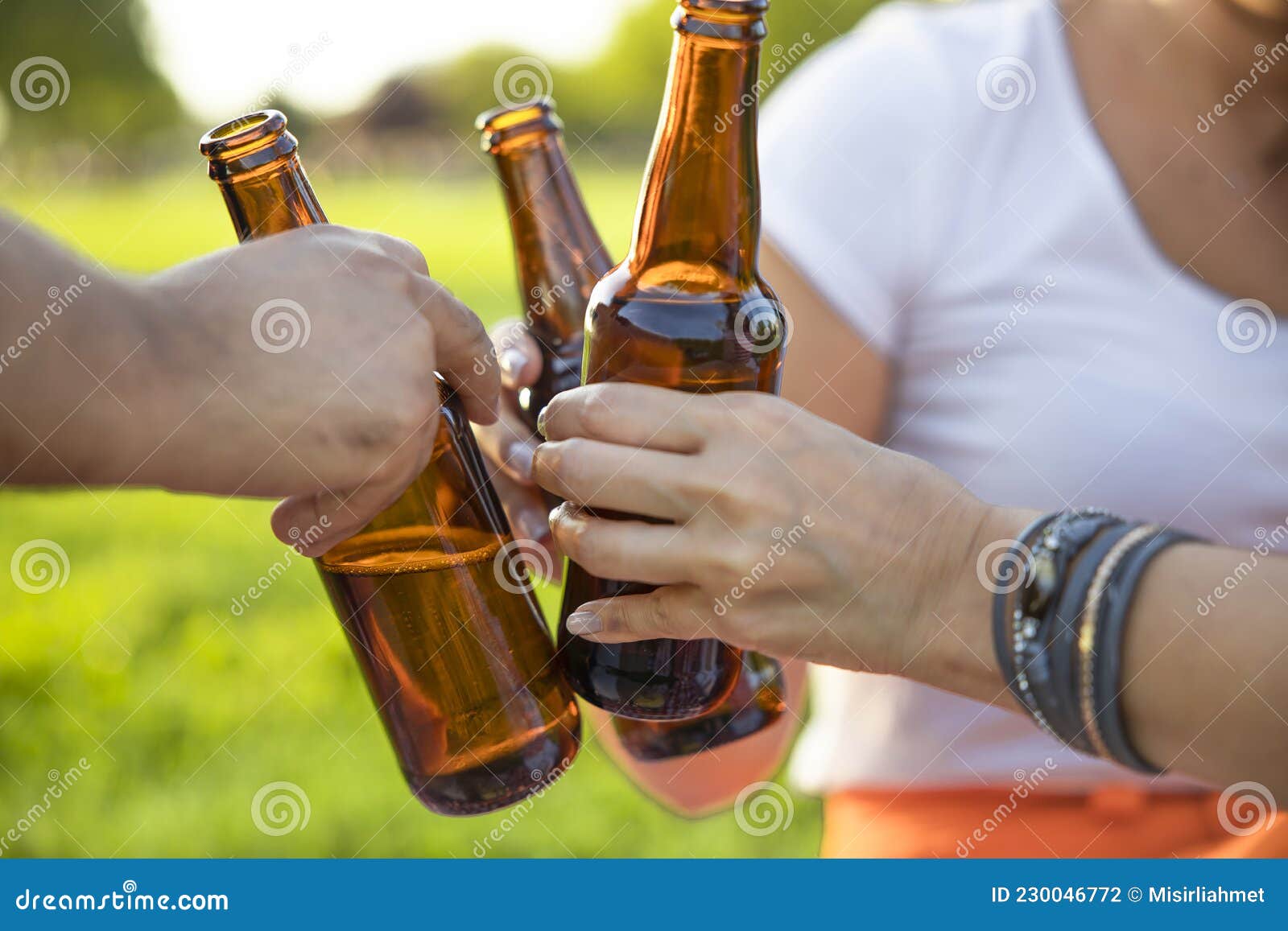 The Hands Holding Bottles with Beer and Cheers Stock Photo - Image of ...