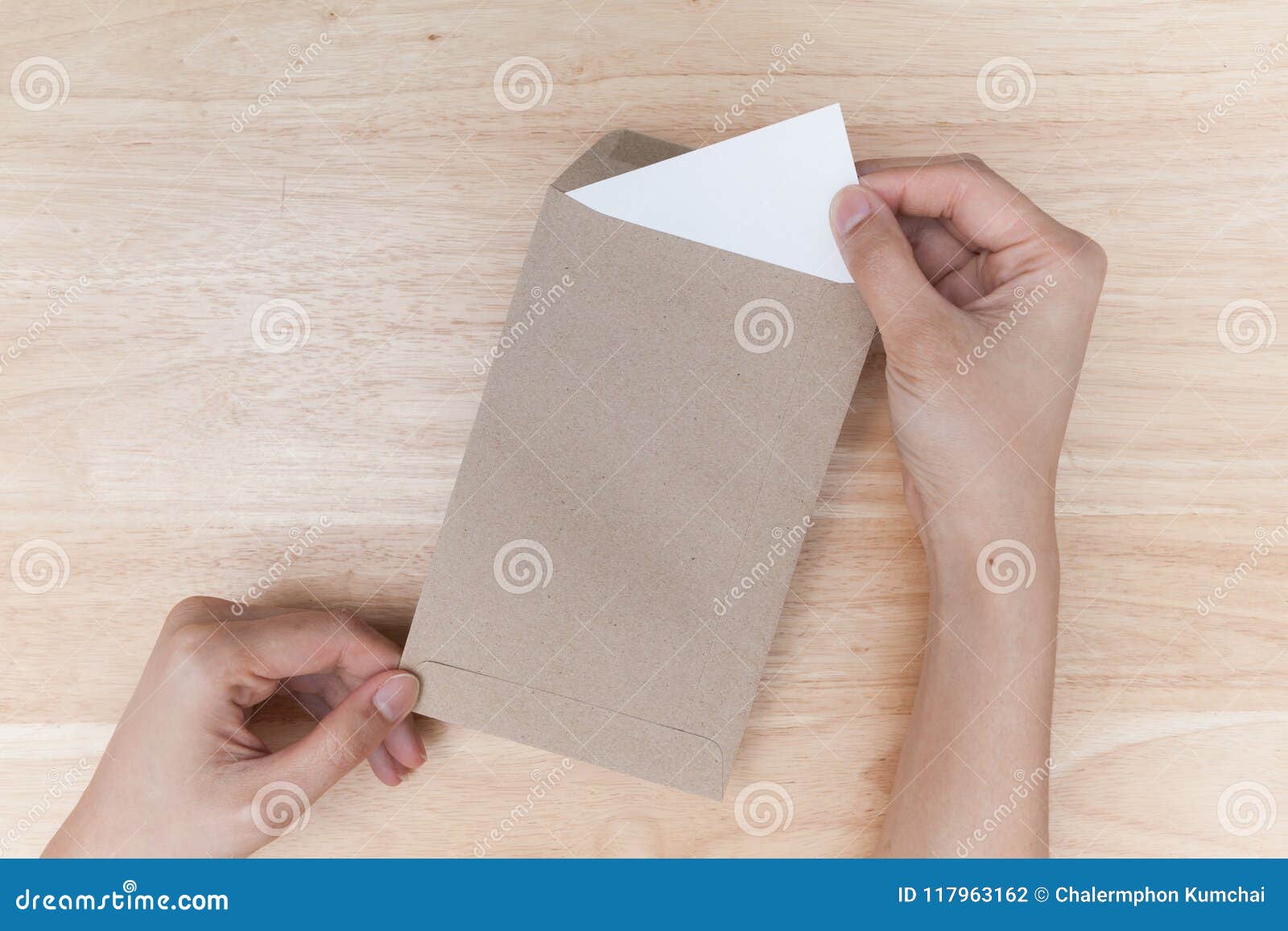 Hands Holding Brown Envelope with a Empty Paper on Wood Background ...