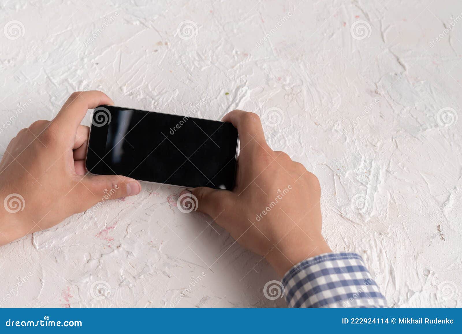 Hands Holding Empty Blank Black Smartphone on a White Surface, Mockup ...