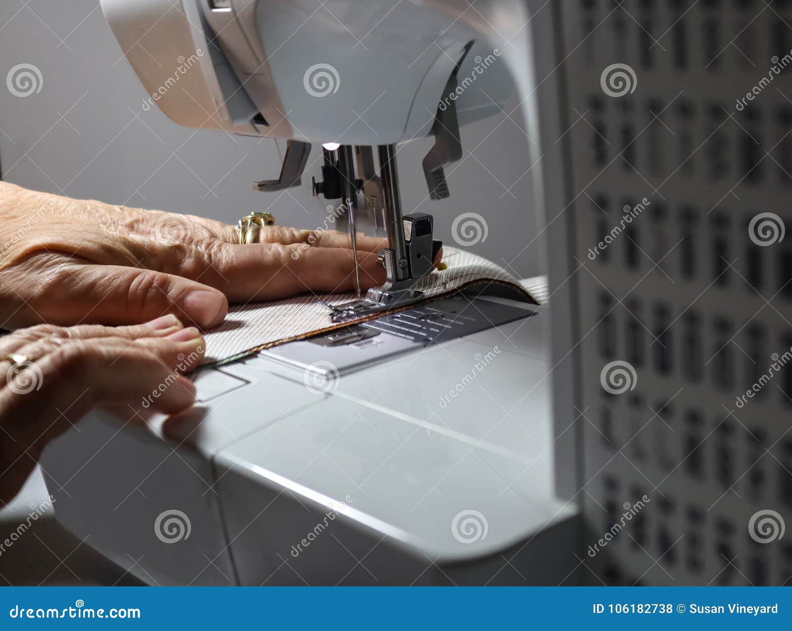 Hands Holding Fabric while Operating a Sewing Machine - Selective Focus ...