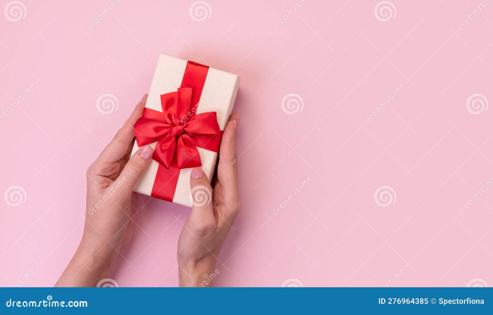 Hands Holding Gift Box with Red Bow on Pink Background. Top View Stock ...