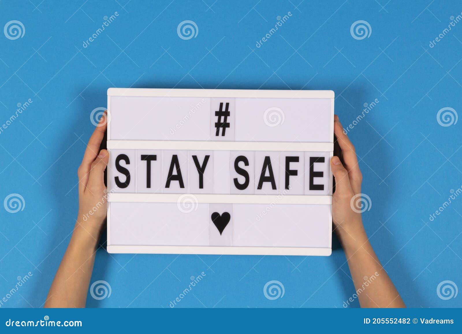 Hands Holding Lightbox with Message Stay Safe on Light Blue Background ...