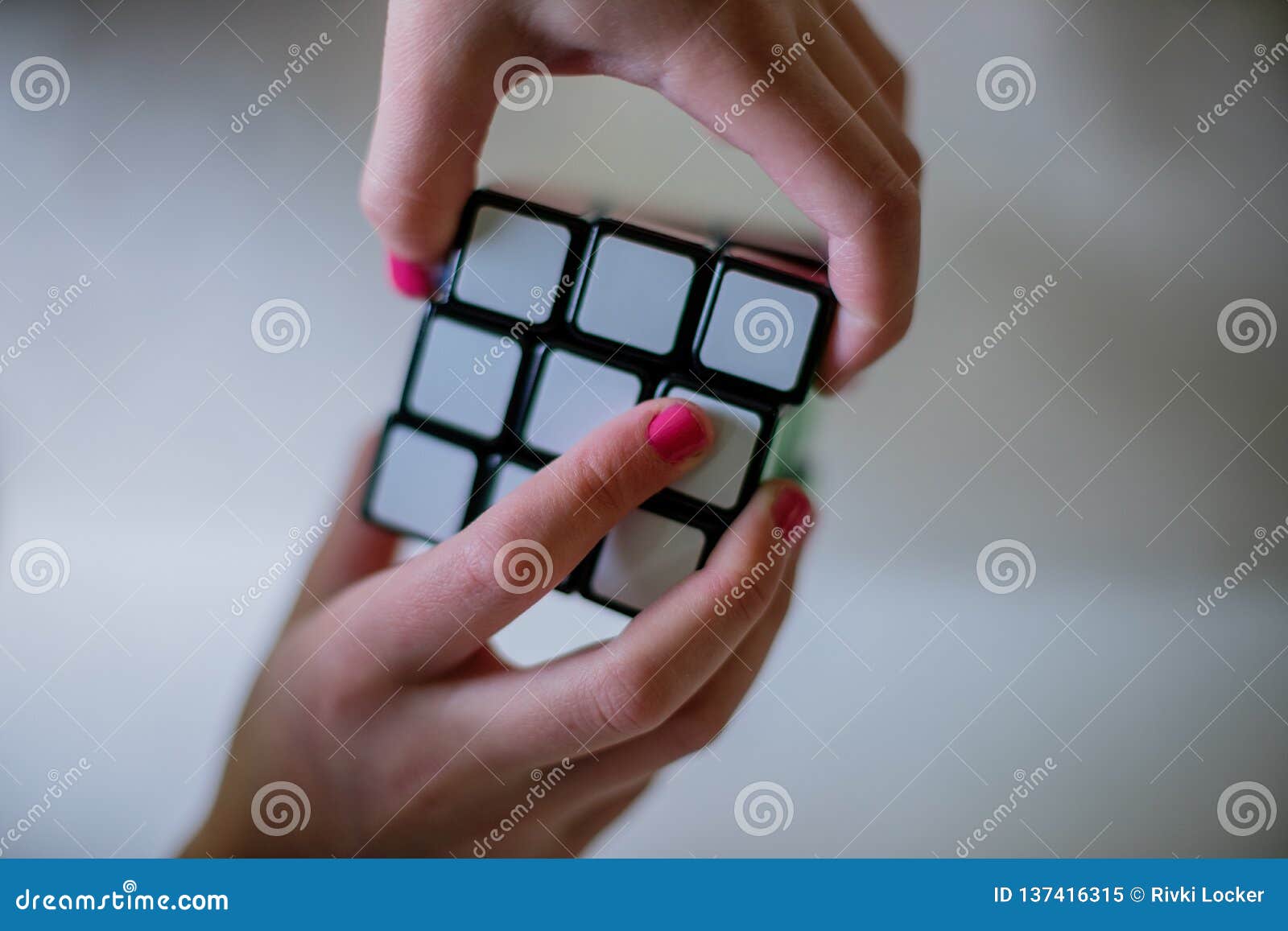 Hands holding Rubiks Cube editorial image. Image of playing - 137416315