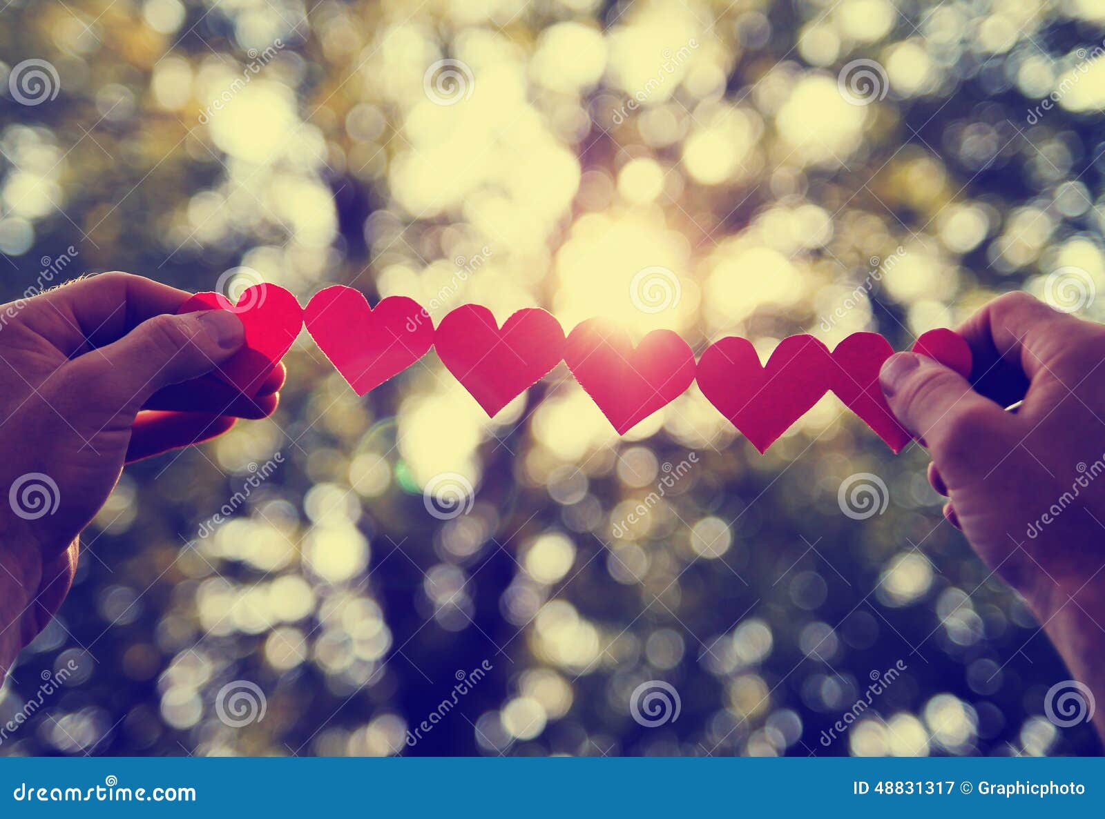 Hands Holding a String of Paper Hearts Up To the Sun Stock Image ...