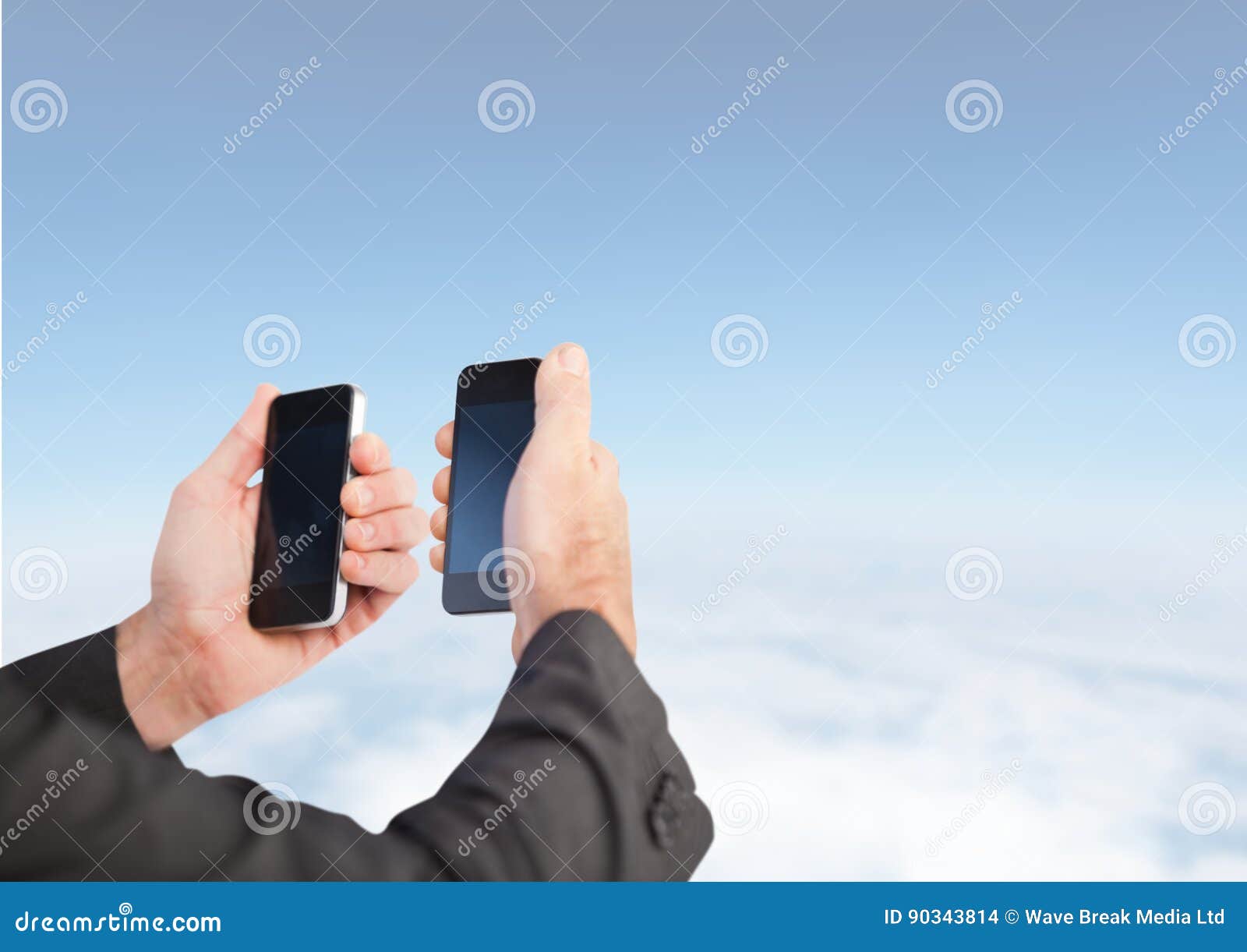 Hands Holding Two Phones at Same Time Against Blue Sky Stock Photo ...