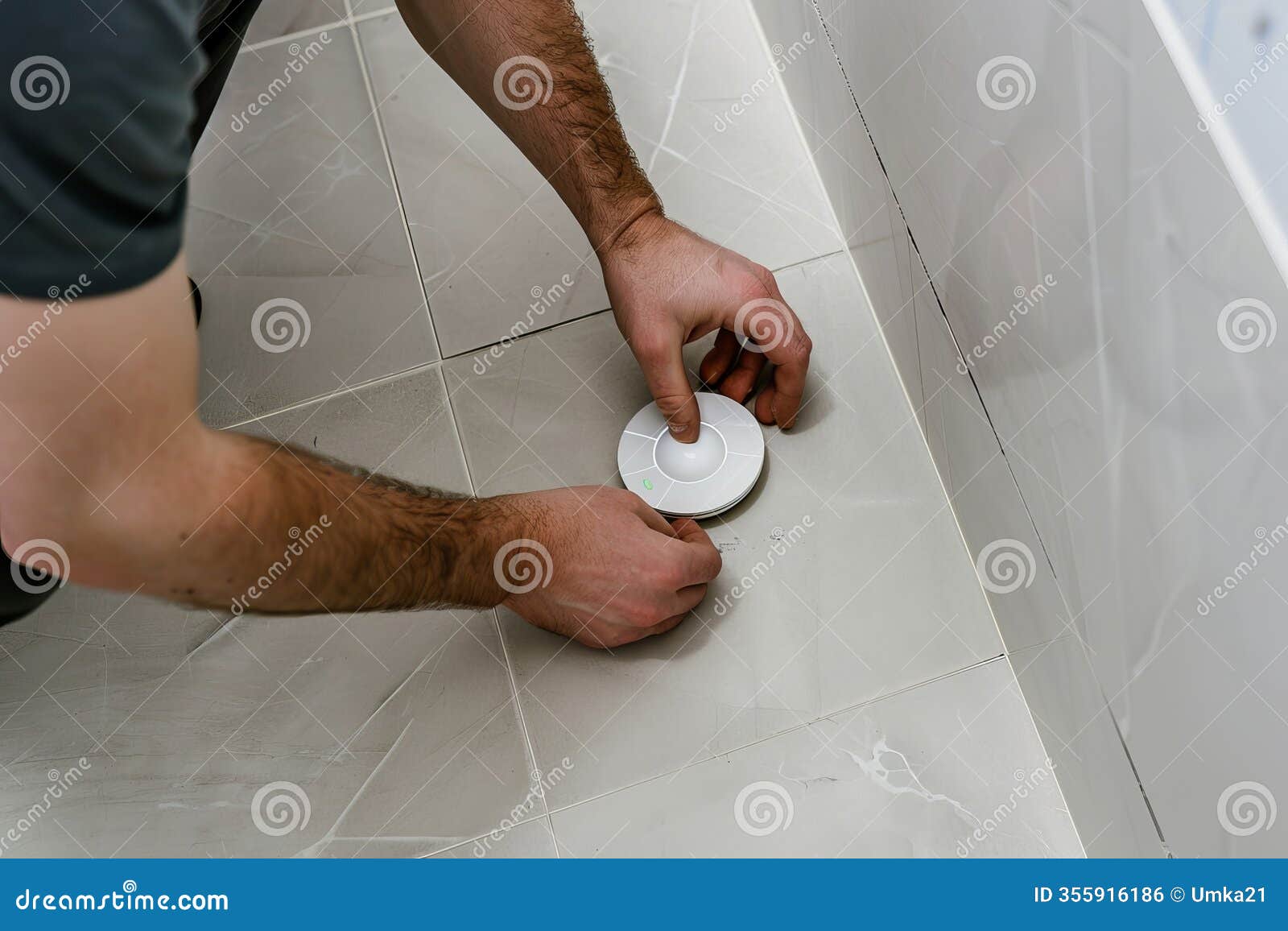 Hands Installing Round Moisture Sensor on Tiled Bathroom Floor for Home ...