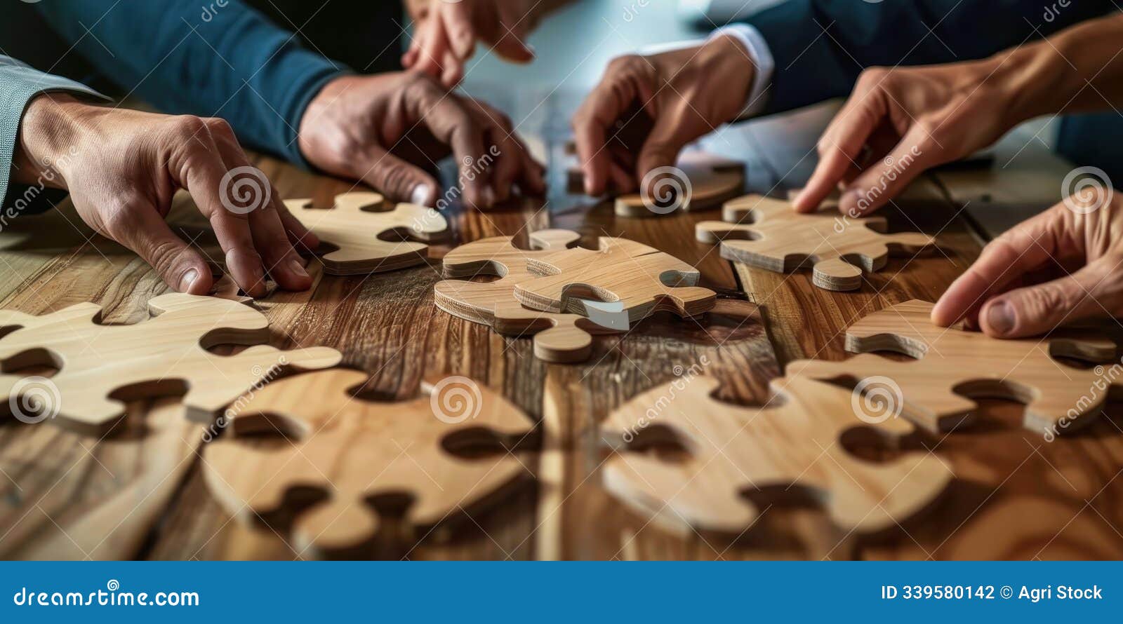 Hands Interlocking Wooden Puzzle Pieces on a Tabletop Stock ...