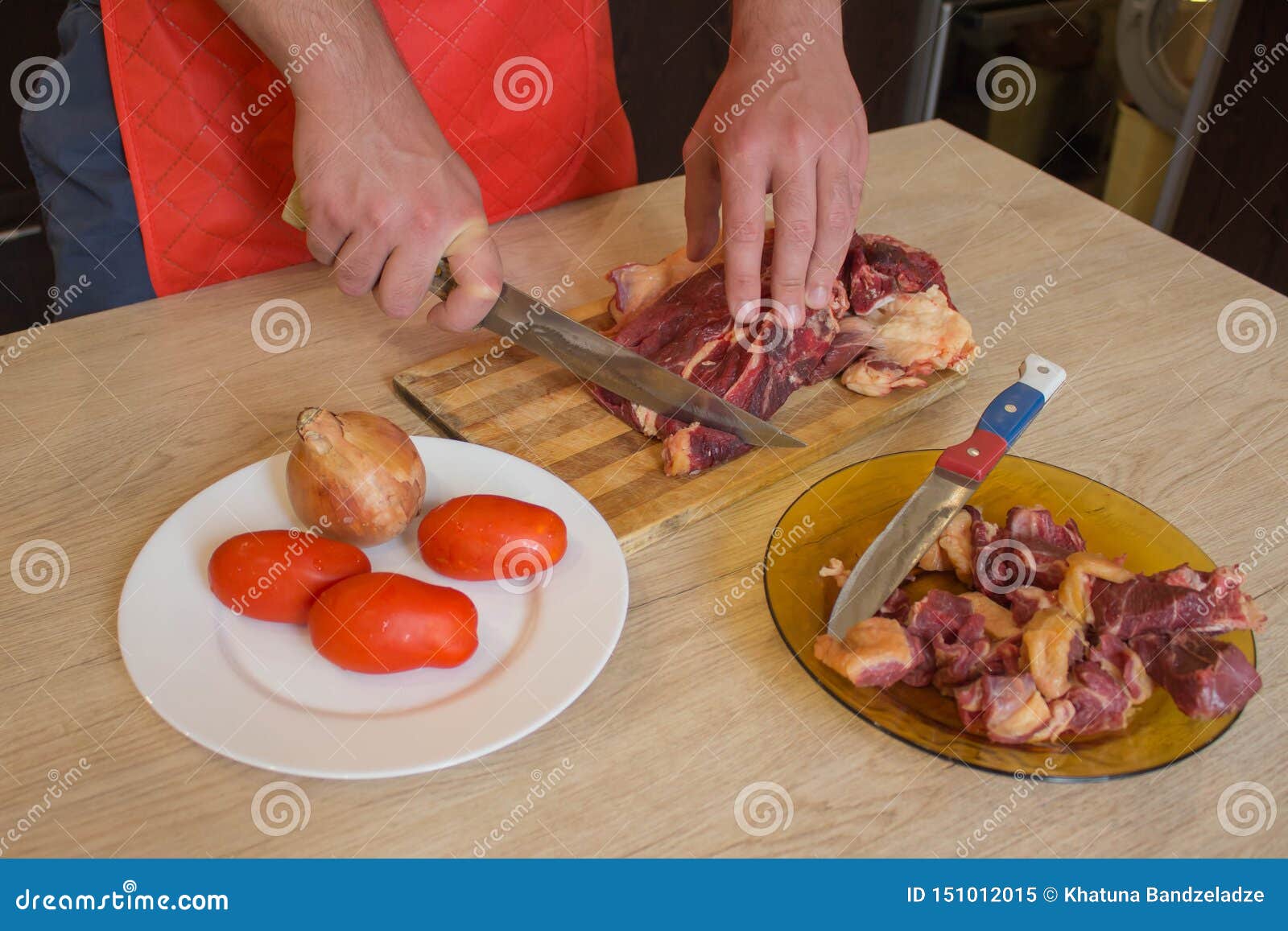 Hands of a Man Preparing Meat and Vegetables in a Kitchen. Focus on ...