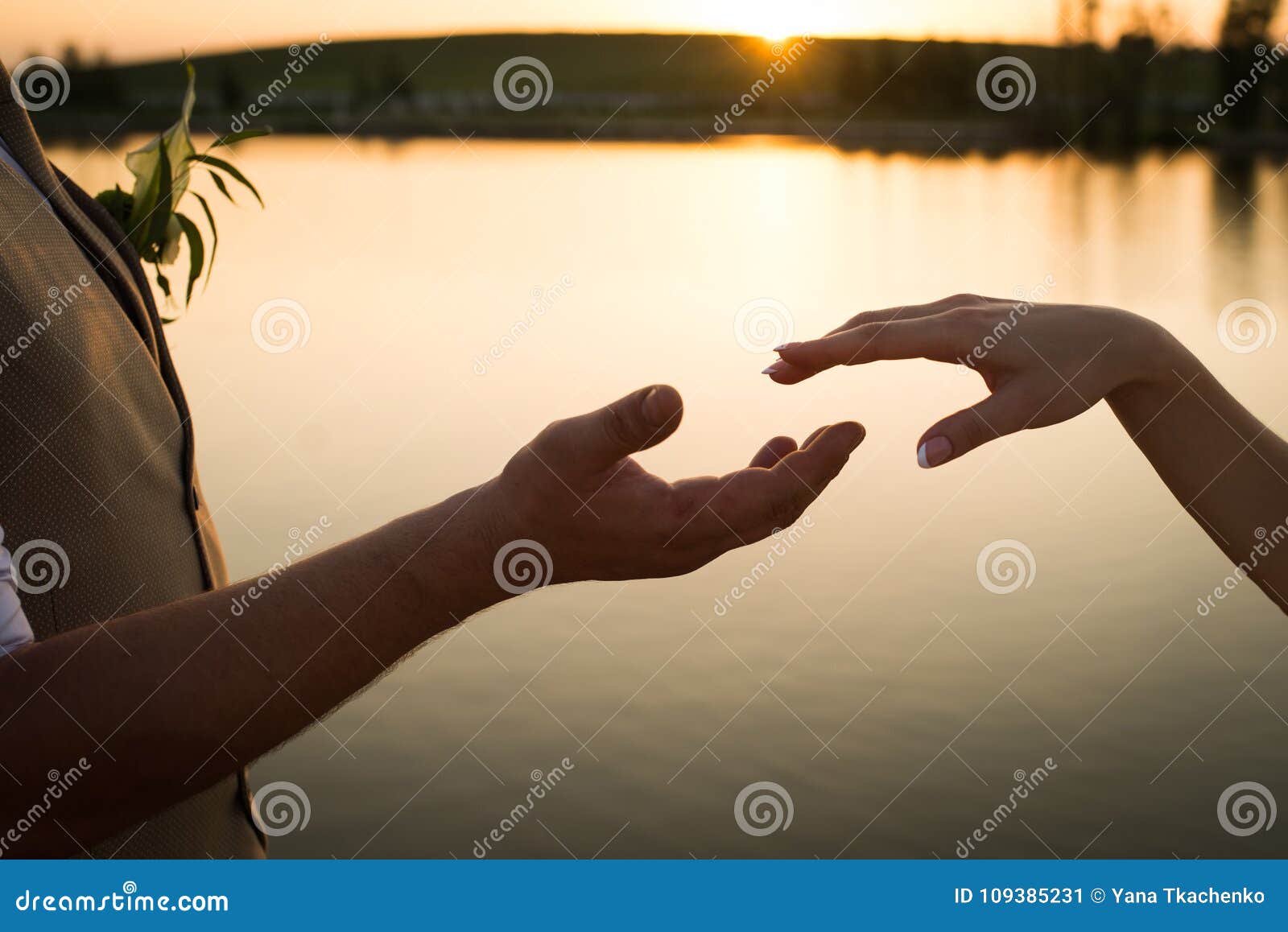 Hands of Man and Woman Reaching To Each Other on a Sunset Background ... Hands of Man and Woman Reaching To Each Other on a Sunset Background ...