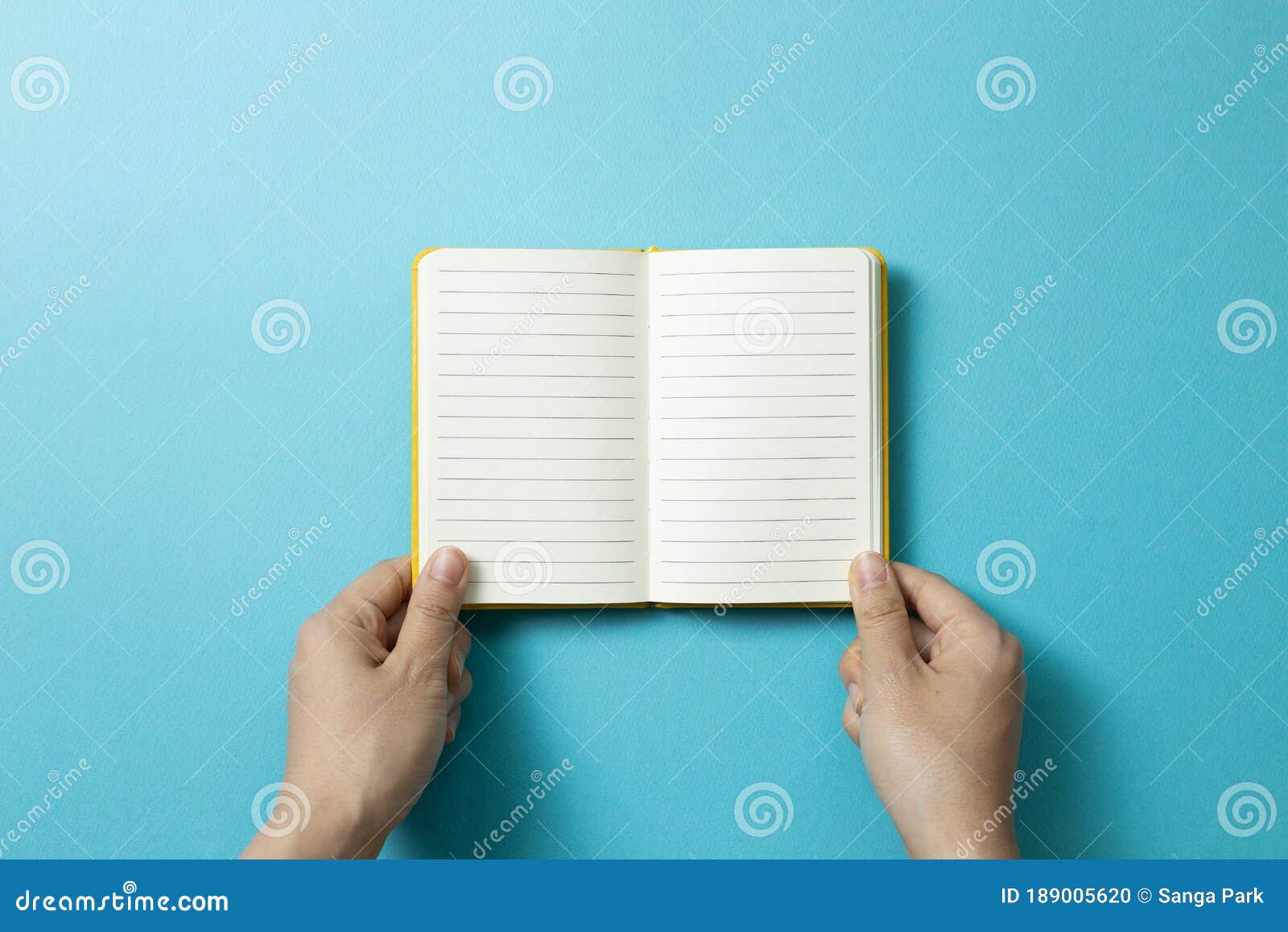 Hands Open Empty Notebook on Blue Background Stock Photo - Image of ...