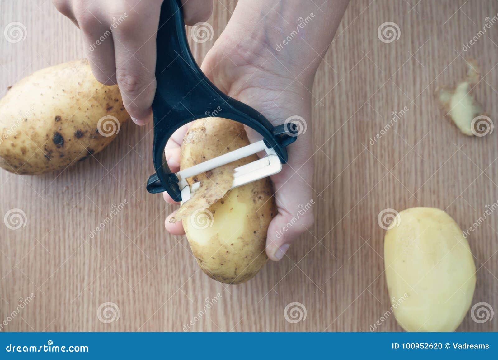 Hands Peeling Potato with Black Peeler Stock Photo - Image of little ...