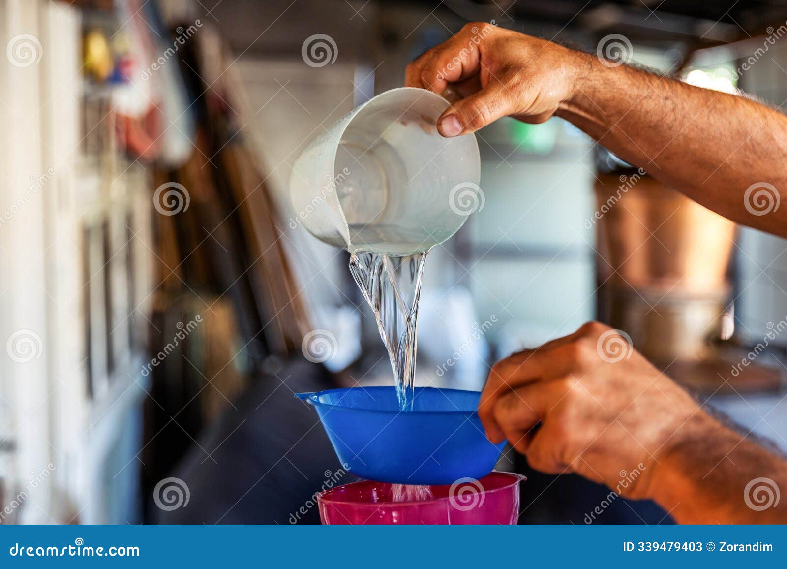 Pouring Liquid through Funnel into Colored Containers Stock Image ...