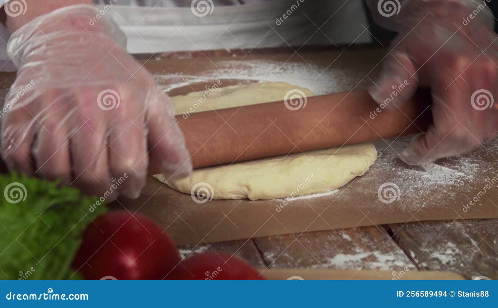 Hands of a Professional Baker Roll Out the Dough with a Rolling Pin on ...