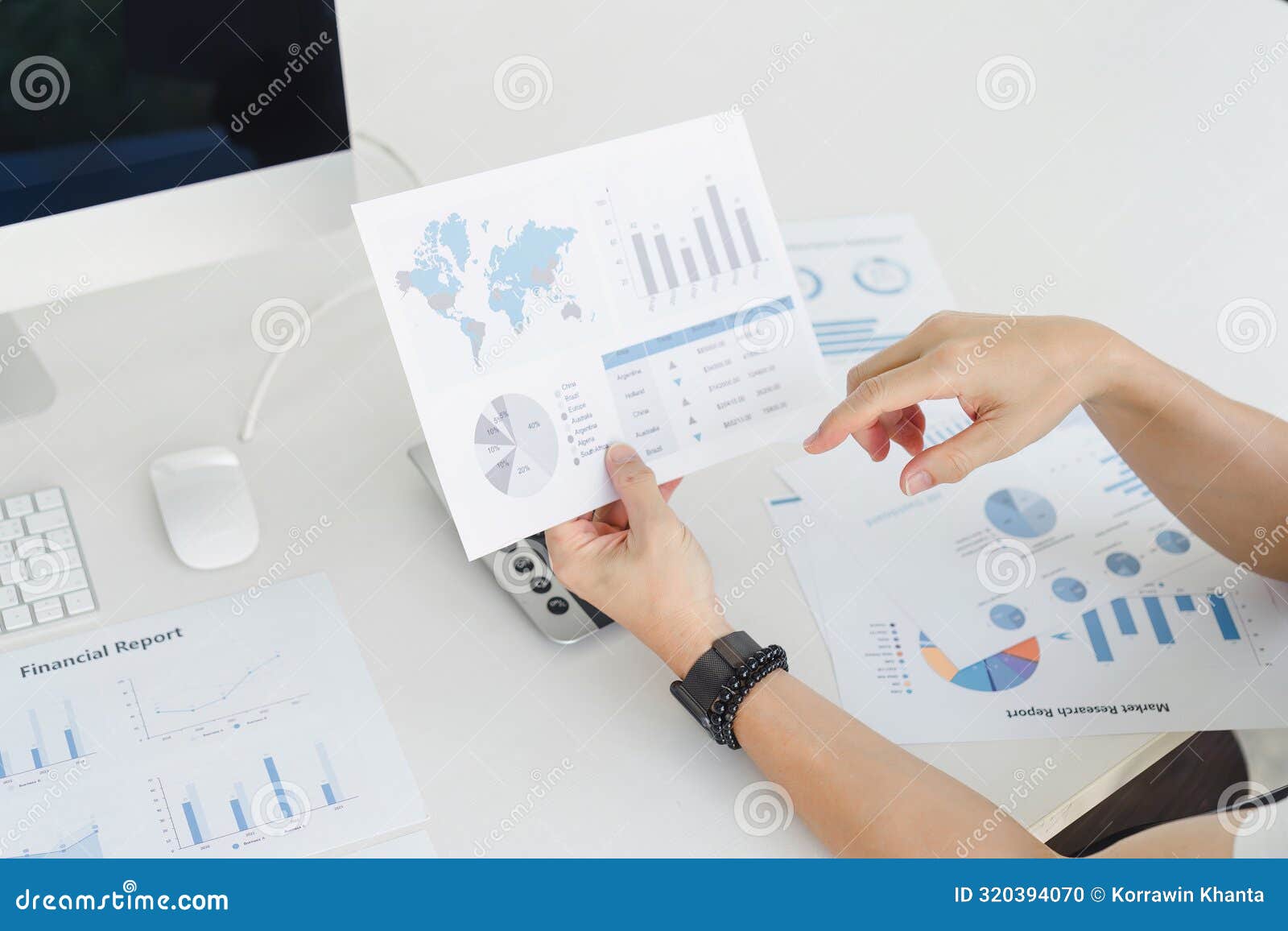 Hands of a Professional Examining a Global Market Analysis Report with ...