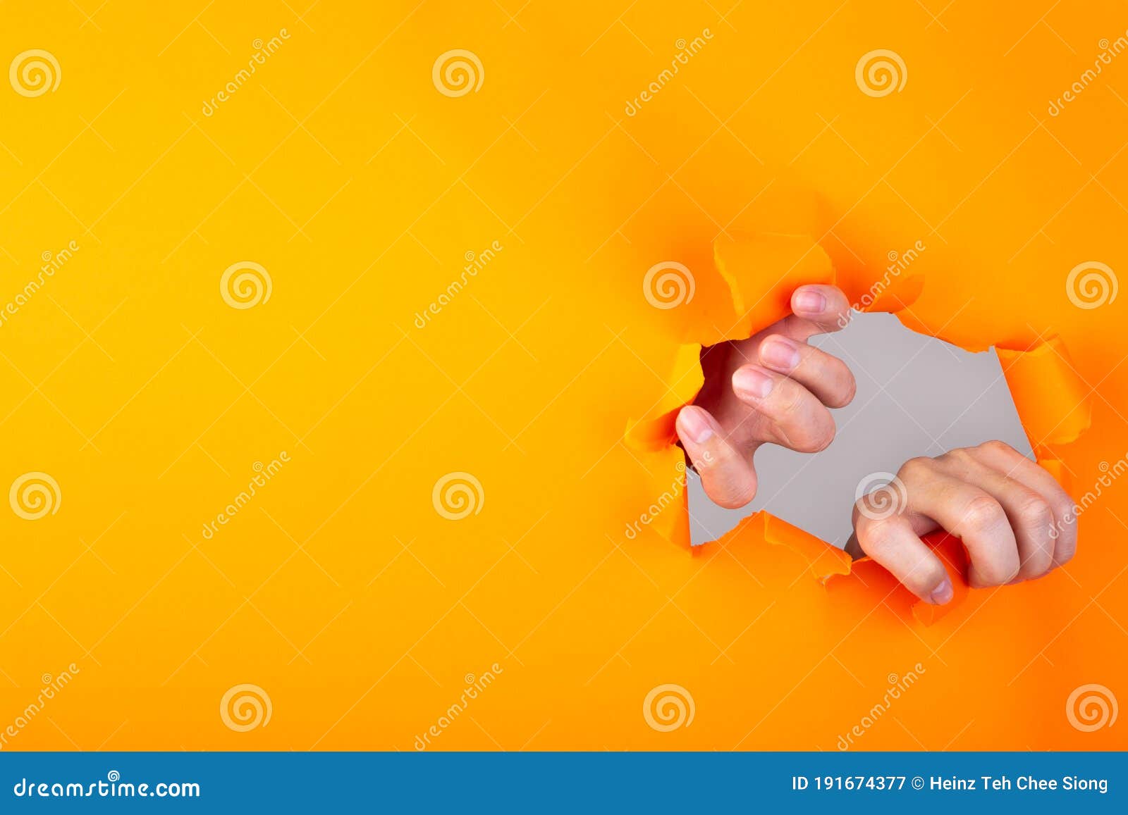 Hands Ripping a Hole in Orange Paper Stock Image - Image of rough, torn ...