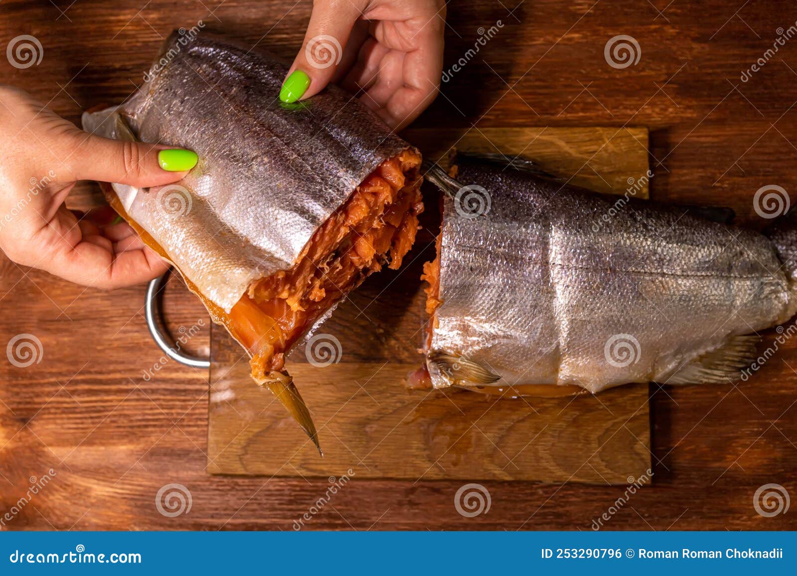 In the Hands of a Salmon Carcass on the Background of a Cutting Board ...