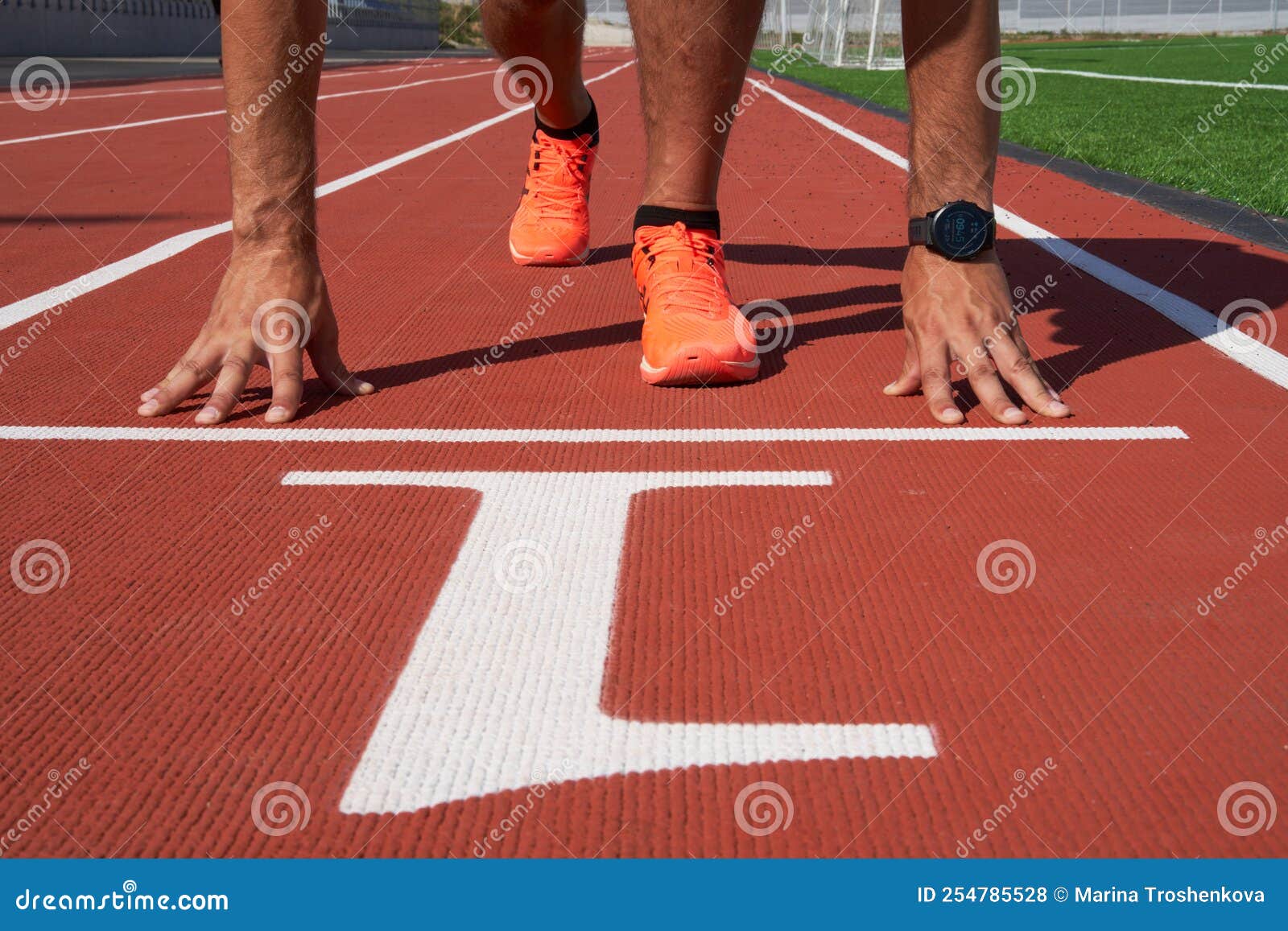 Hands on the Starting Line, the Sprinter is Preparing To Start at the ...