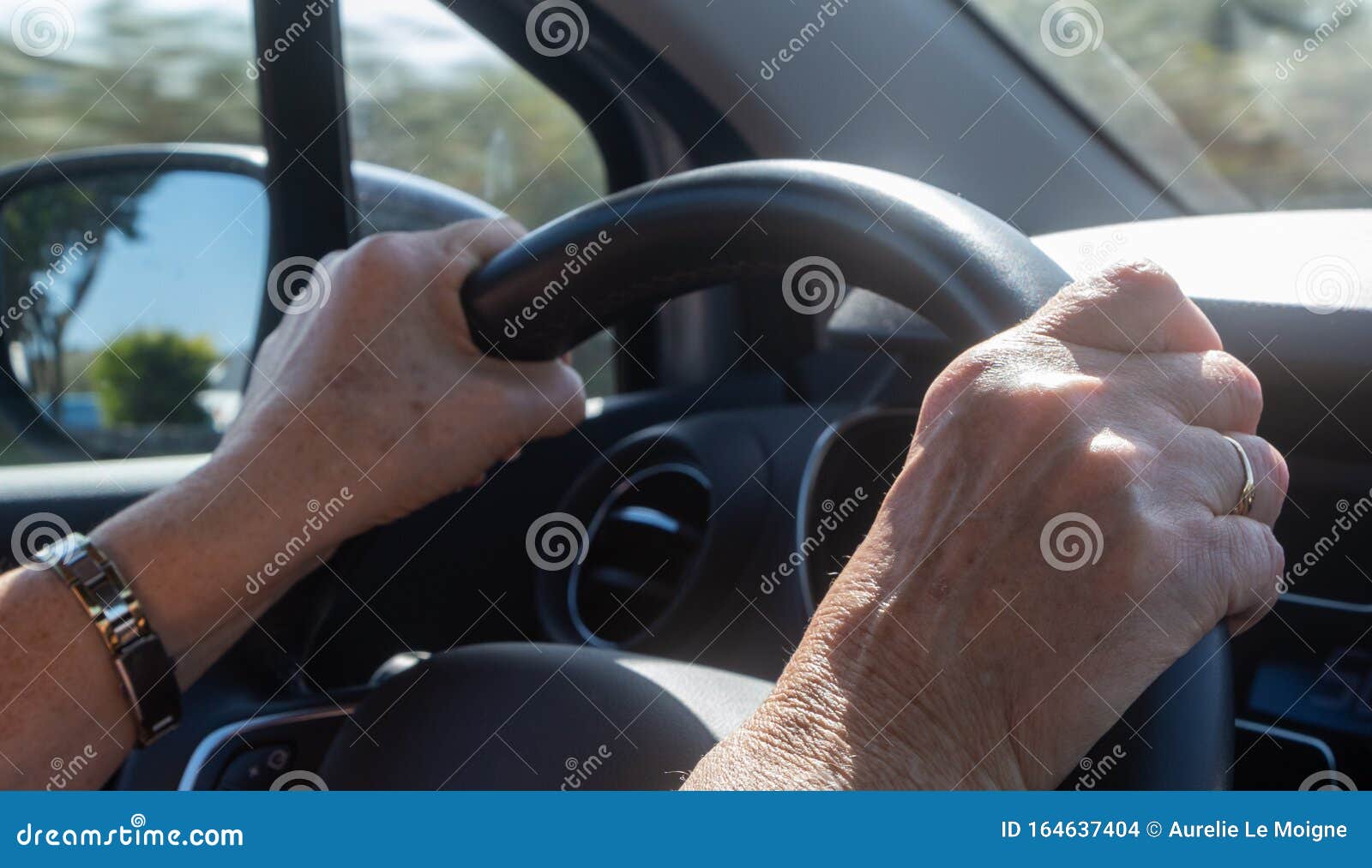 Hands on a steering wheel stock photo. Image of hand - 164637404