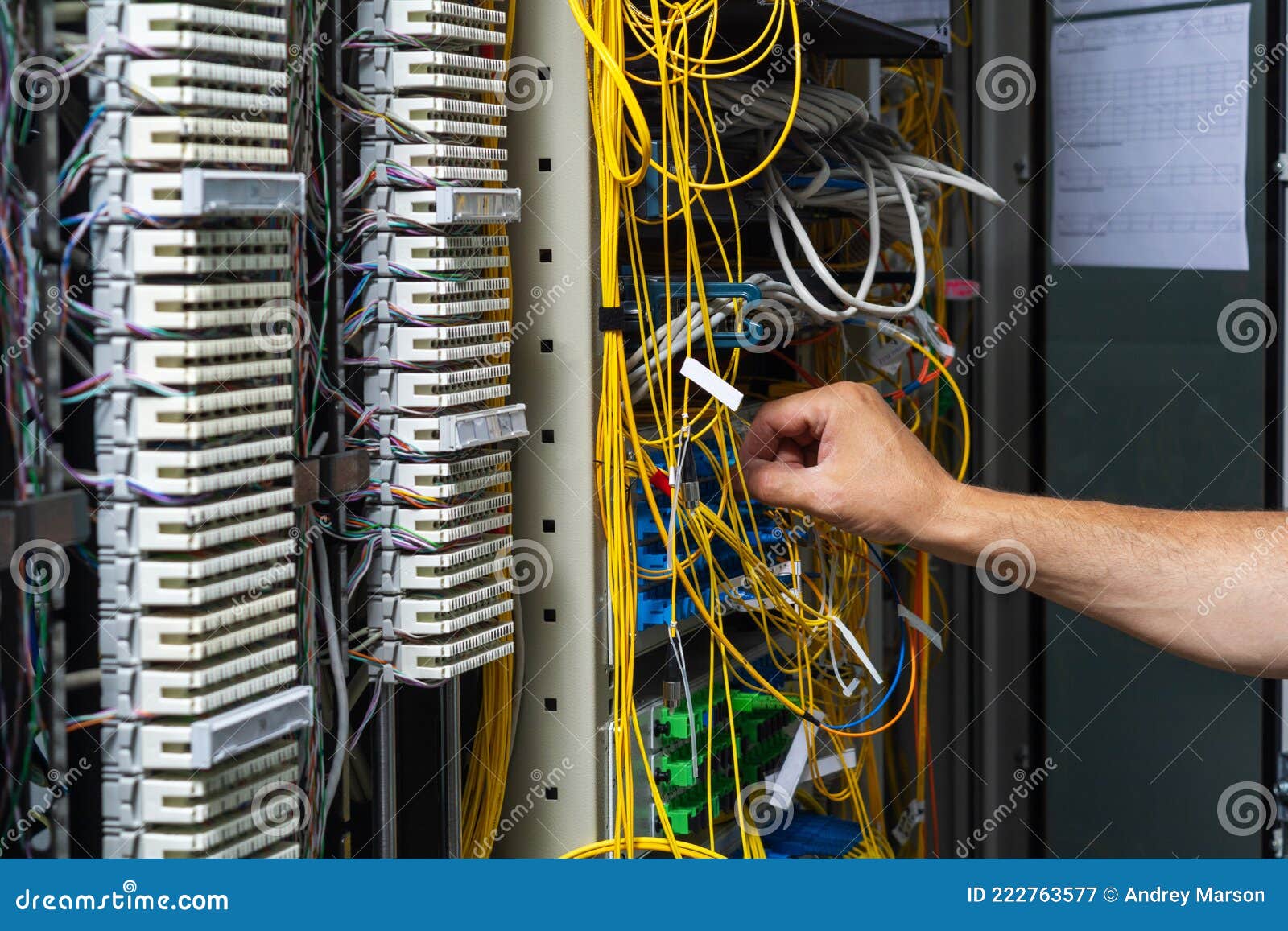 Hands of a Technician Crossing a Telecommunication Panel Cable in a ...