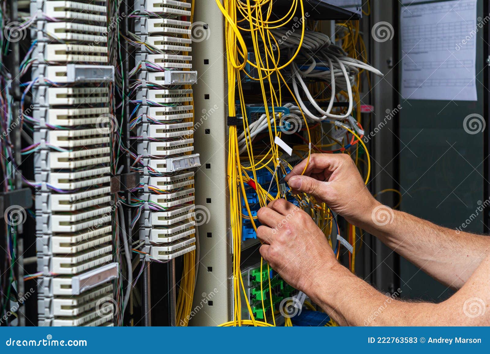 Hands of a Technician Crossing a Telecommunication Panel Cable in a ...