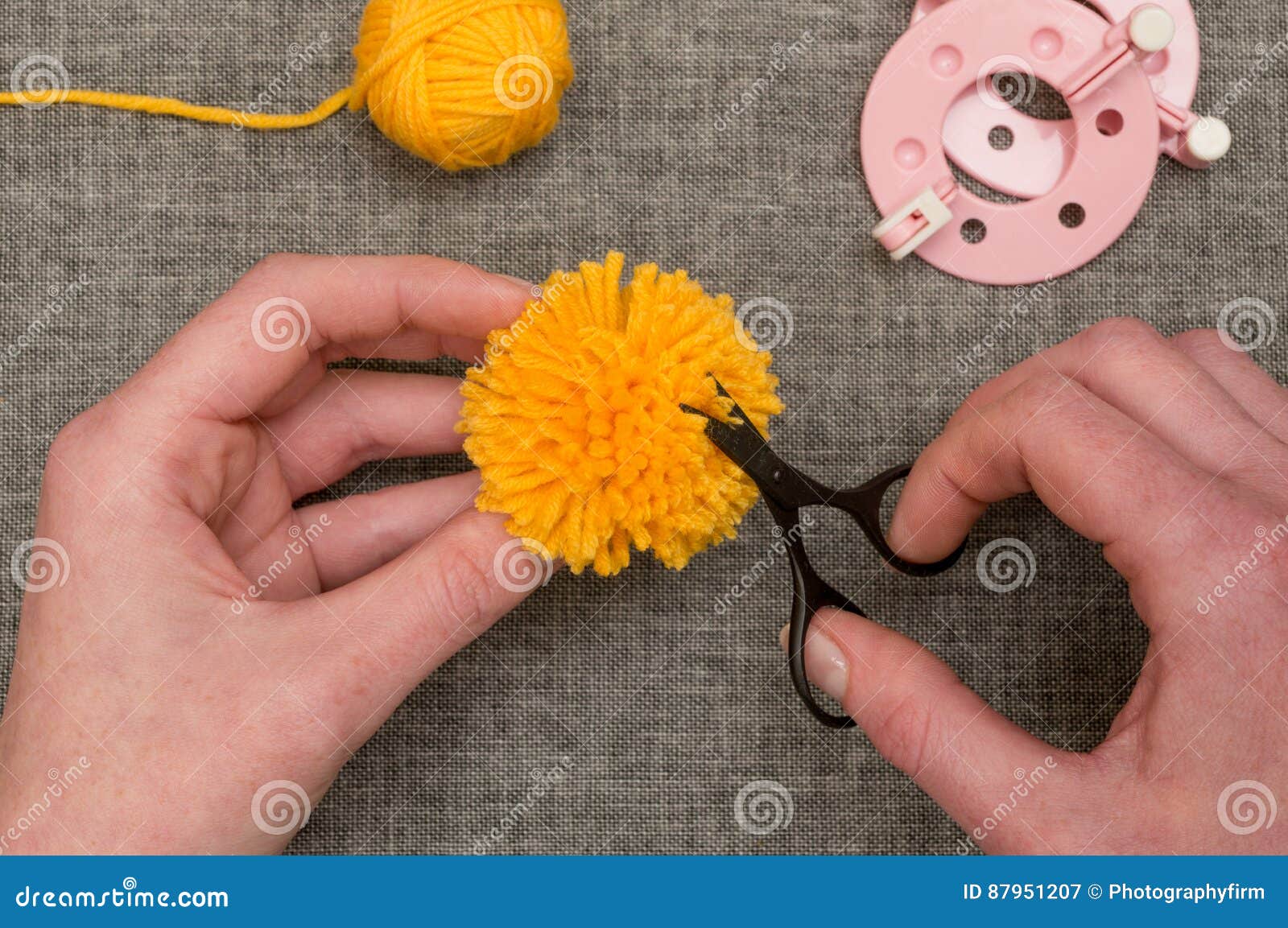 Hands Trimming a Yellow Pom-pom with Thread Scissors Stock Image ...