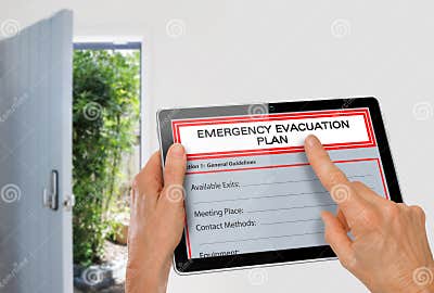Hands Using Tablet with Emergency Evacuation Plan beside Exit Door ...