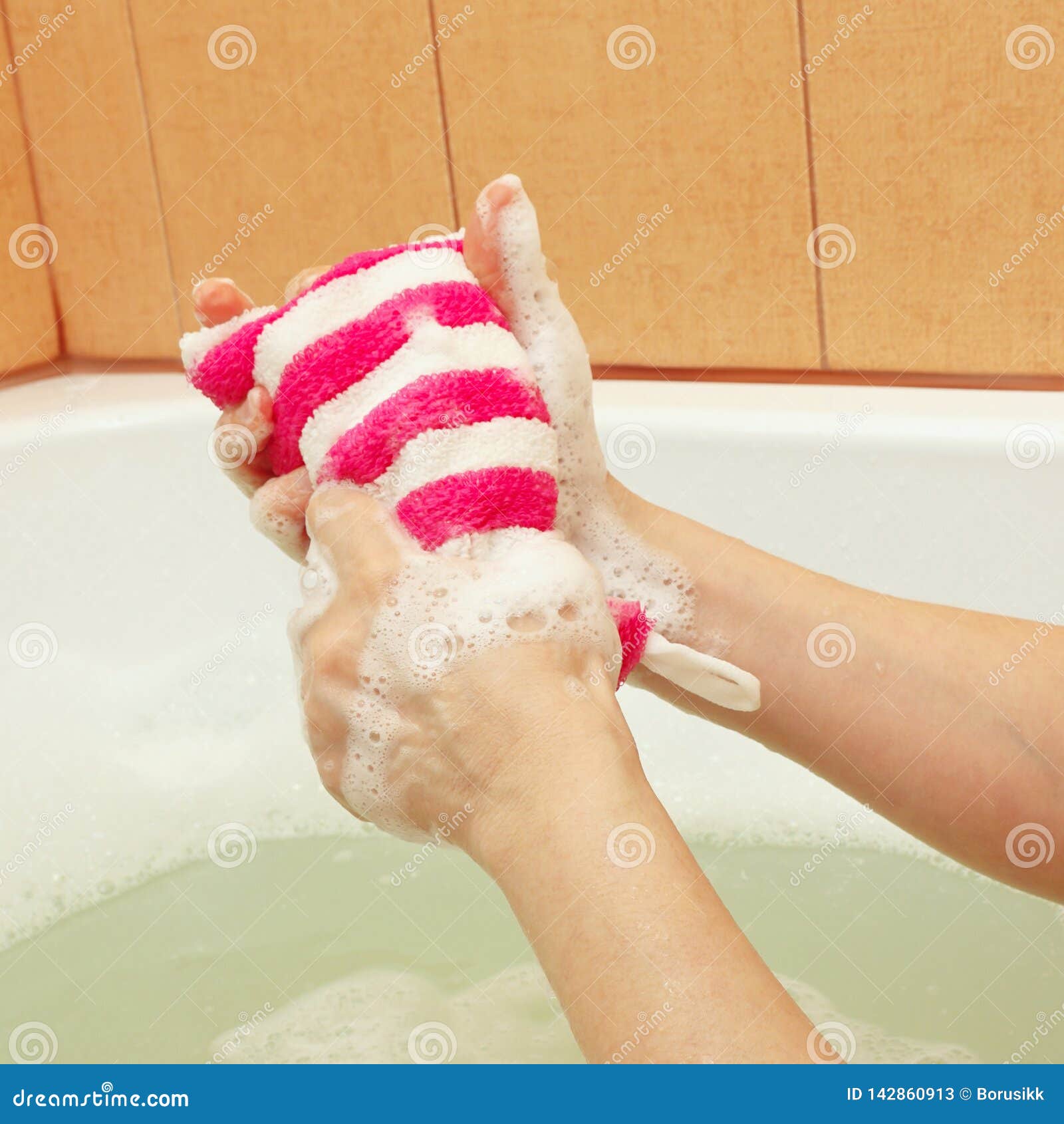 Hands of Woman Lathering Striped Sponge in the Bathroom Stock Image ...