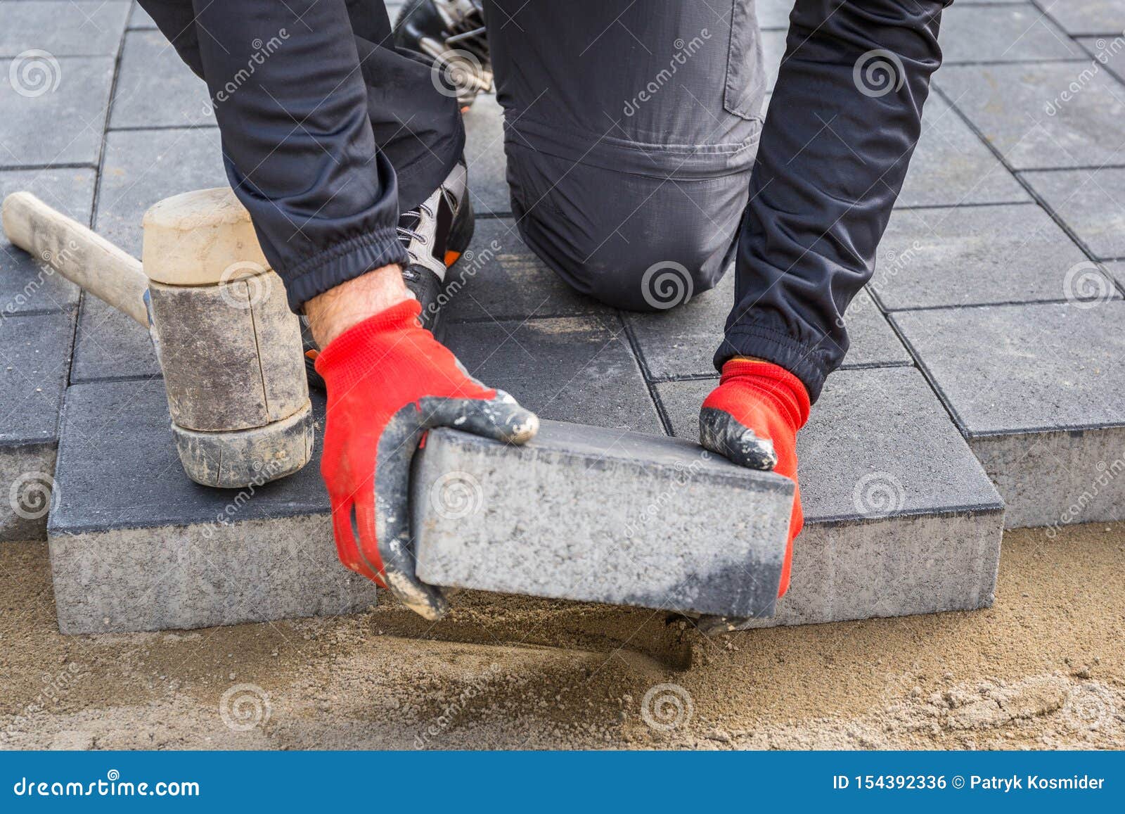 Hands of Worker Installing Concrete Paver Blocks with Rubber Hammer ...