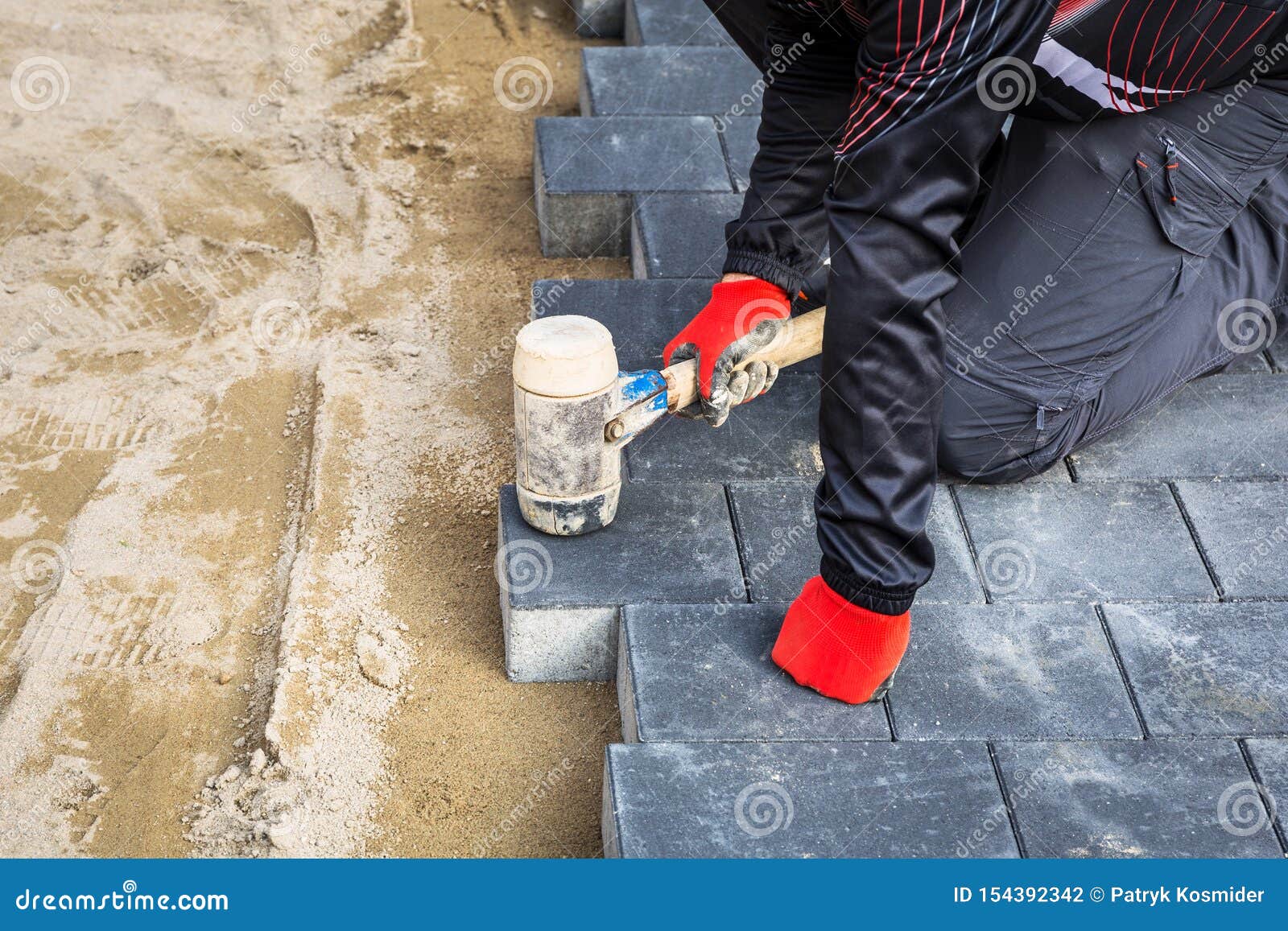 Hands of Worker Installing Concrete Paver Blocks with Rubber Hammer ...