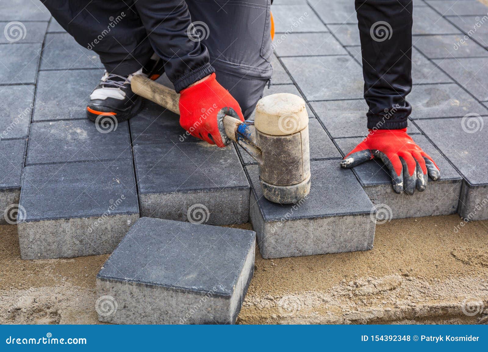 Hands of Worker Installing Concrete Paver Blocks with Rubber Hammer ...