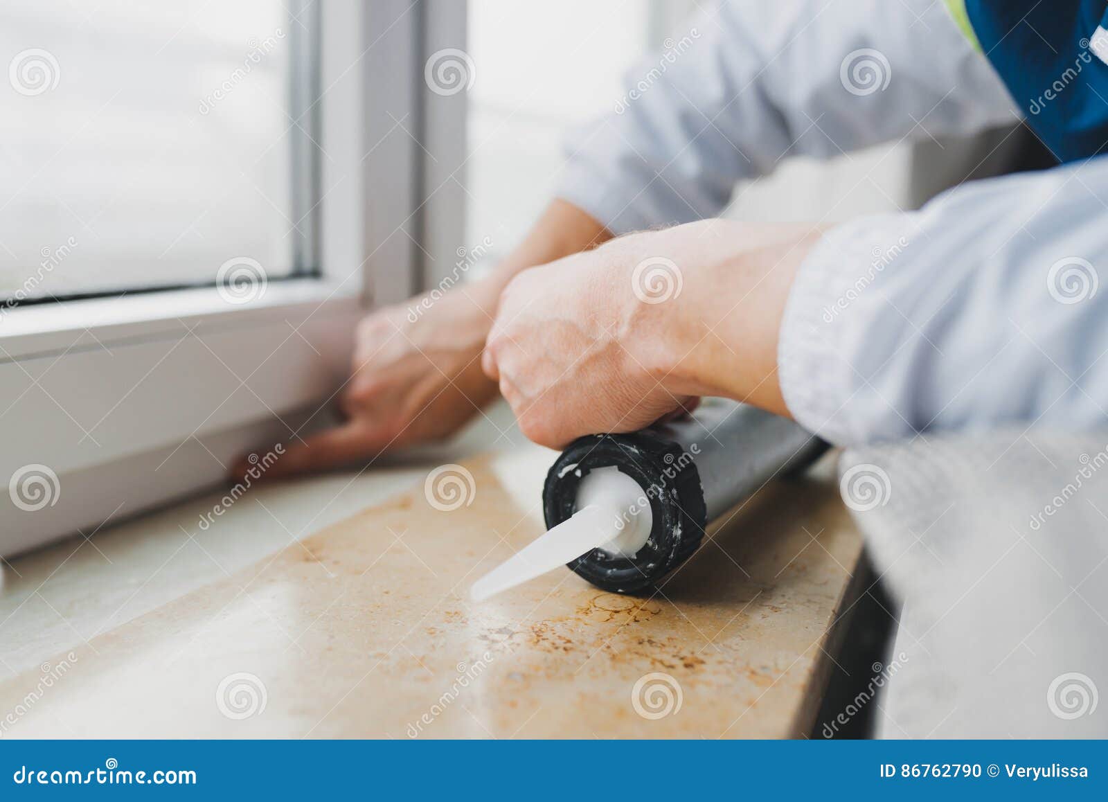 Hands of Worker Using a Silicone Tube for Repairing of Window Stock ...