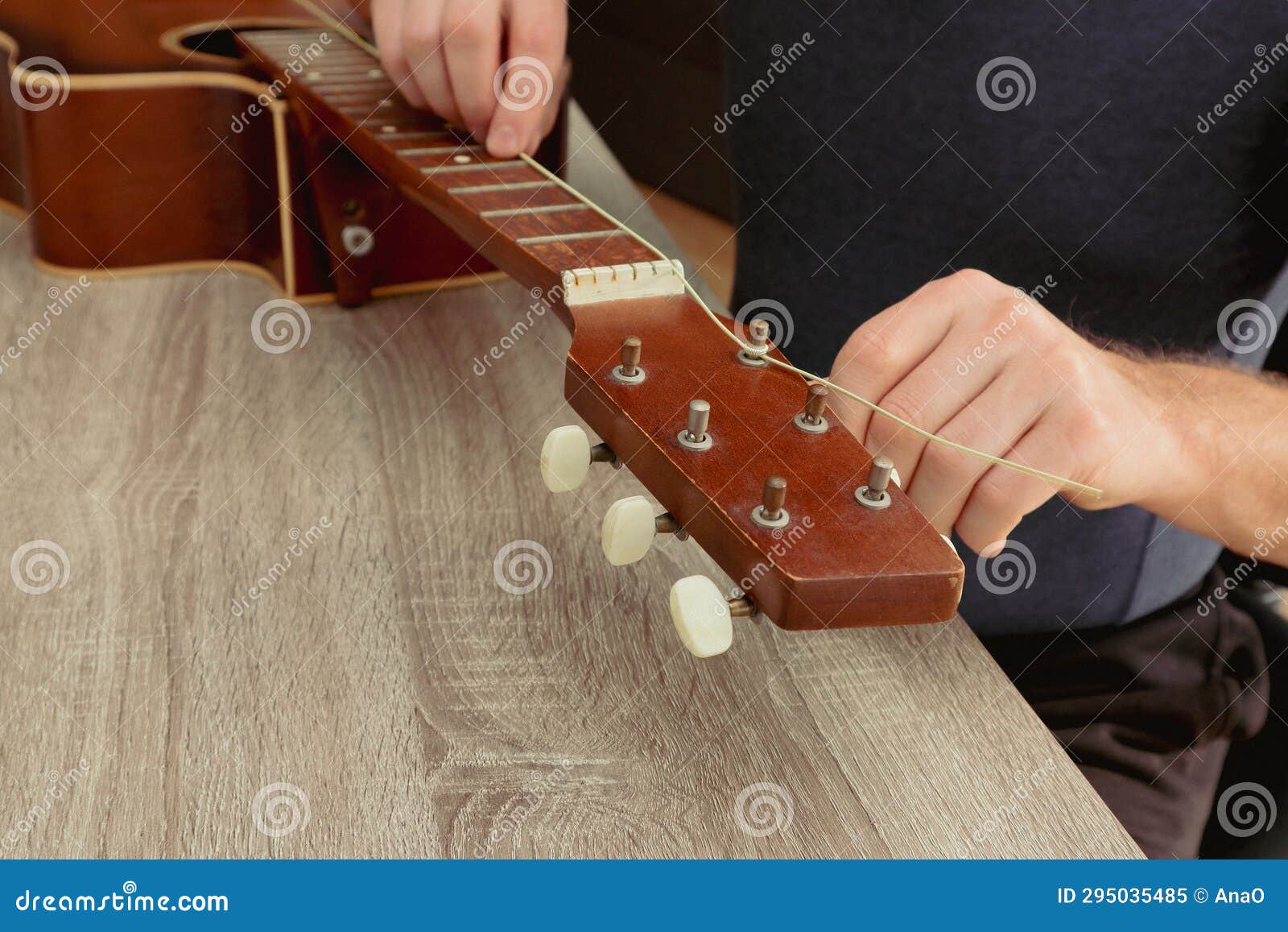 Hands of a Young Man Changing the String on an Acoustic Guitar. Hand ...