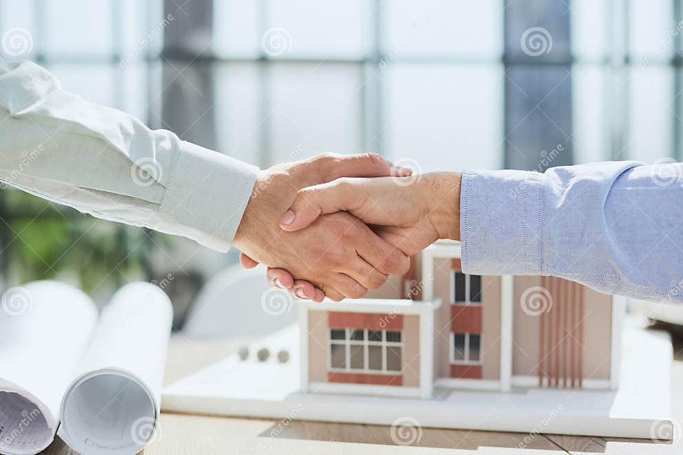 Handshake Against the Background of a Model of a House Under ...