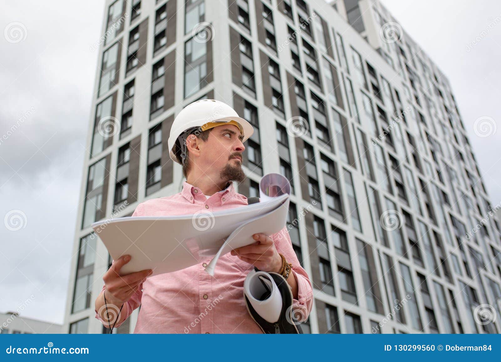 Portrait of Architect at Work with Helmet in a Construction Site, Reads ...