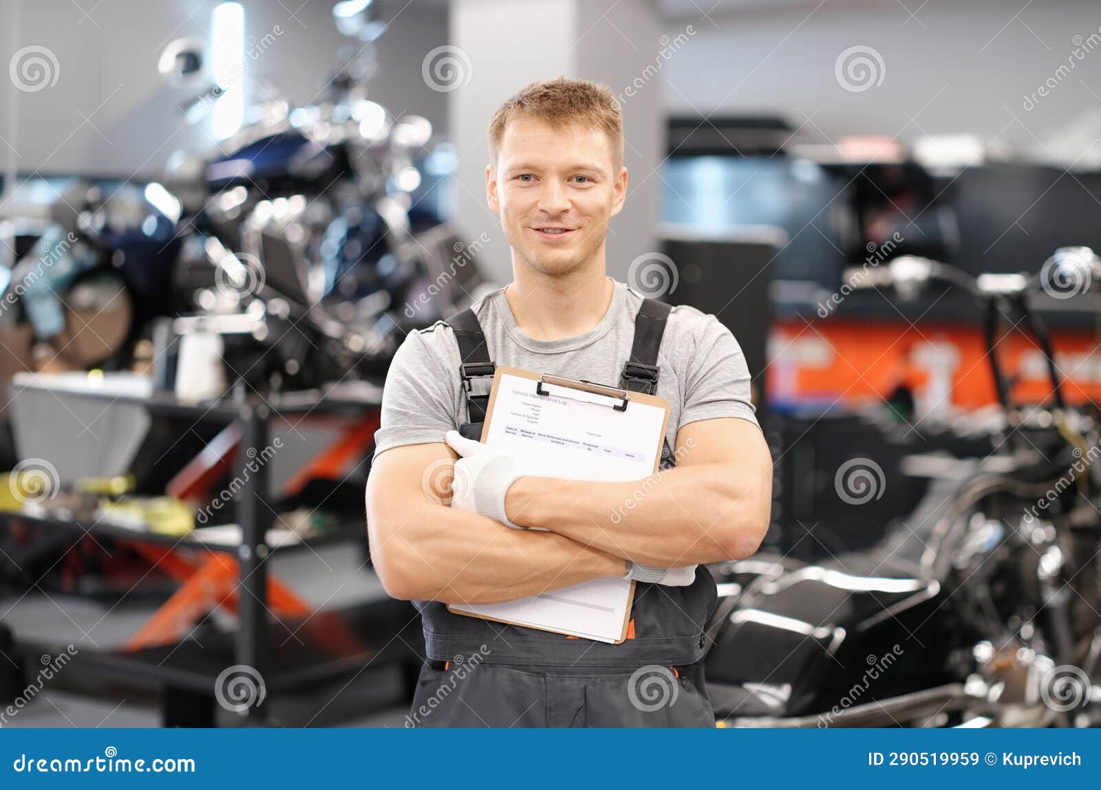 Handsome Auto Mechanic Posing in Car Service and Holding Documents in ...