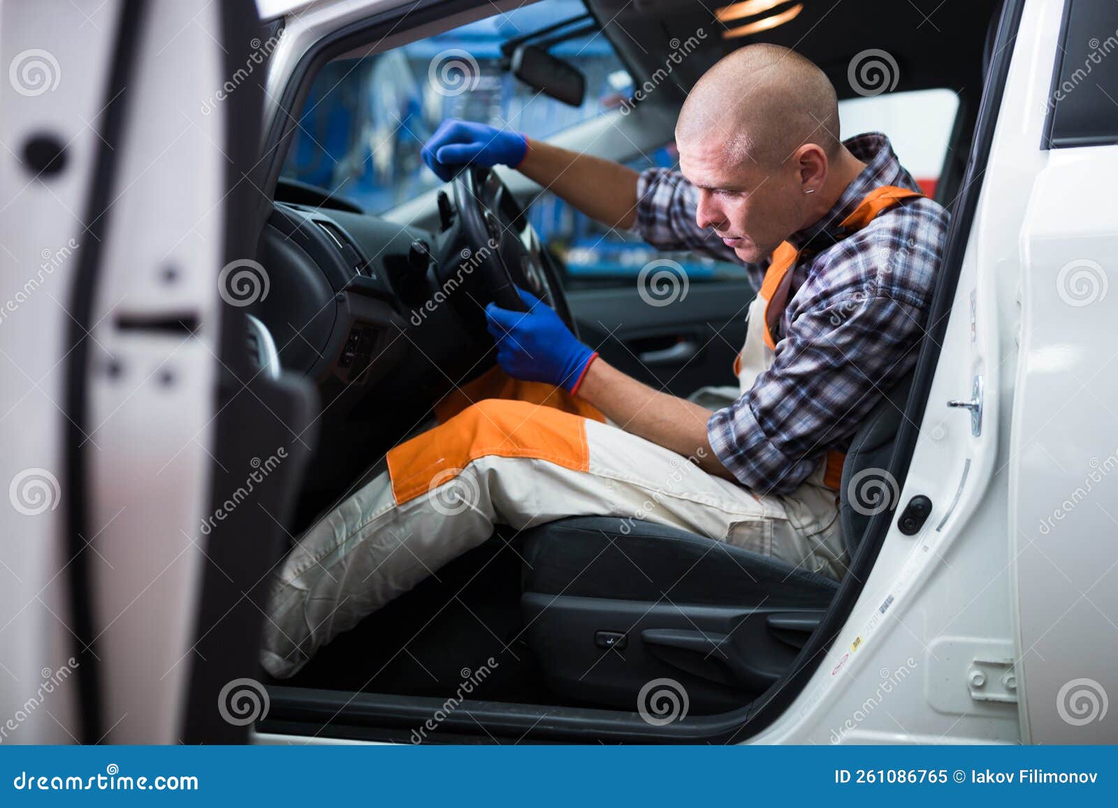 Auto Mechanic Sitting in Broken Car and Listens To Engine Operation ...