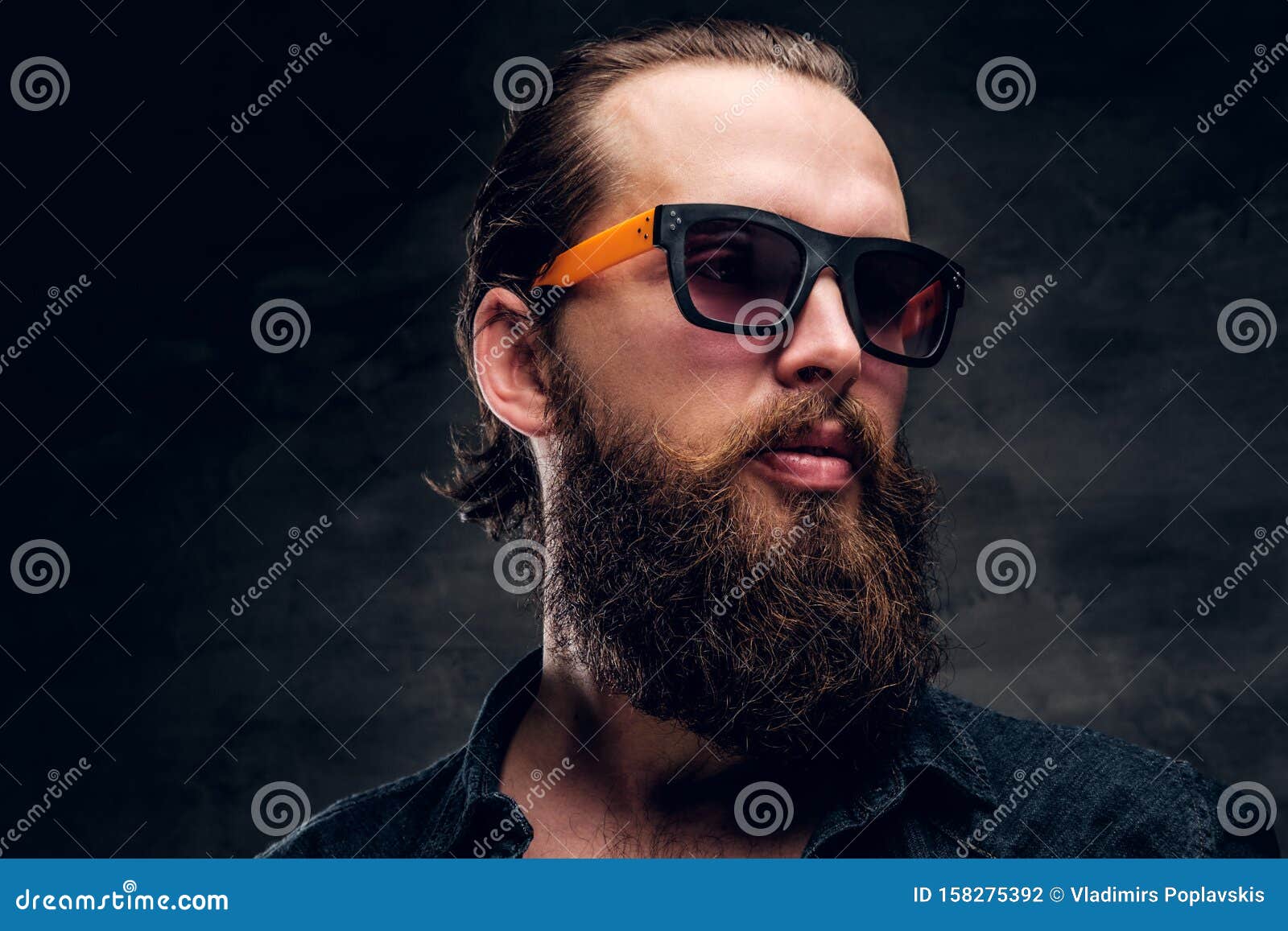 Bearded Man In Sunglasses Is Posing For Photographer At Dark Photo