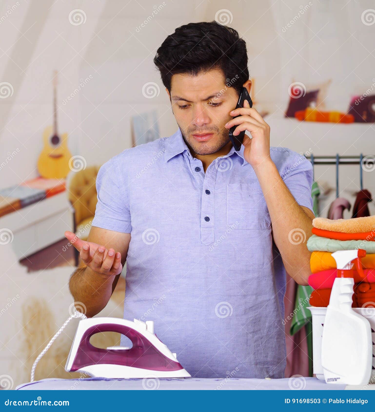 Handsome Beautiful Young Man Ironing Clothes on Ironing Board while he ...
