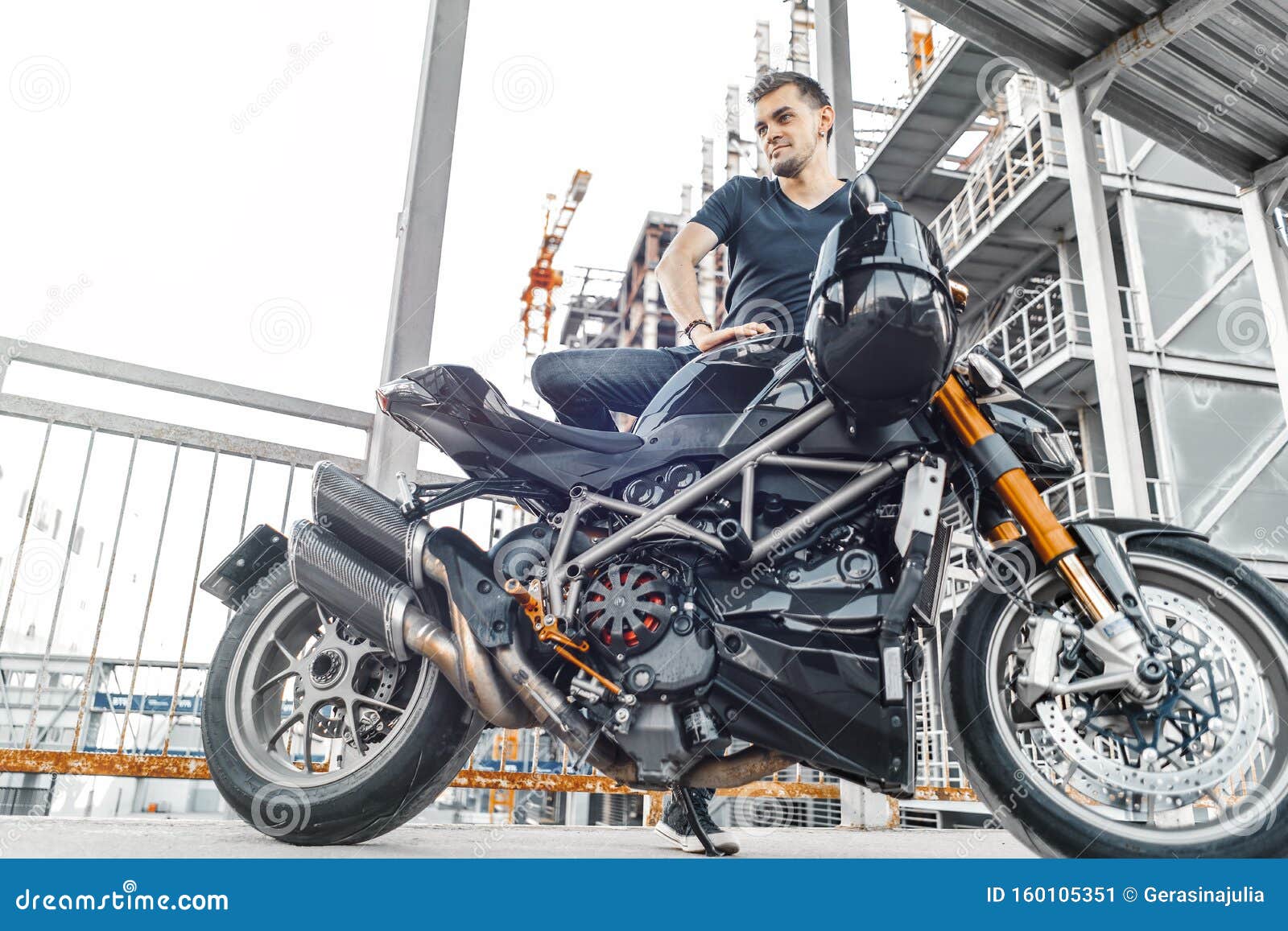 Handsome Biker Sitting Down on Black Motorcycle on Urban Background at ...