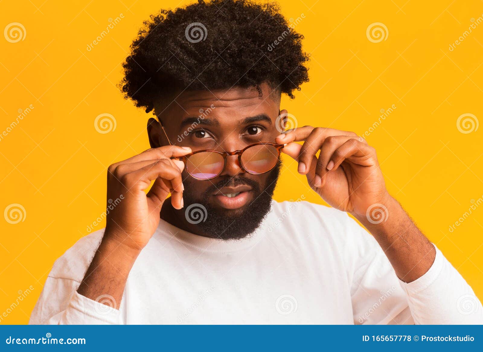 Handsome Black Man Adjusting His Glasses And Looking At Camera Stock