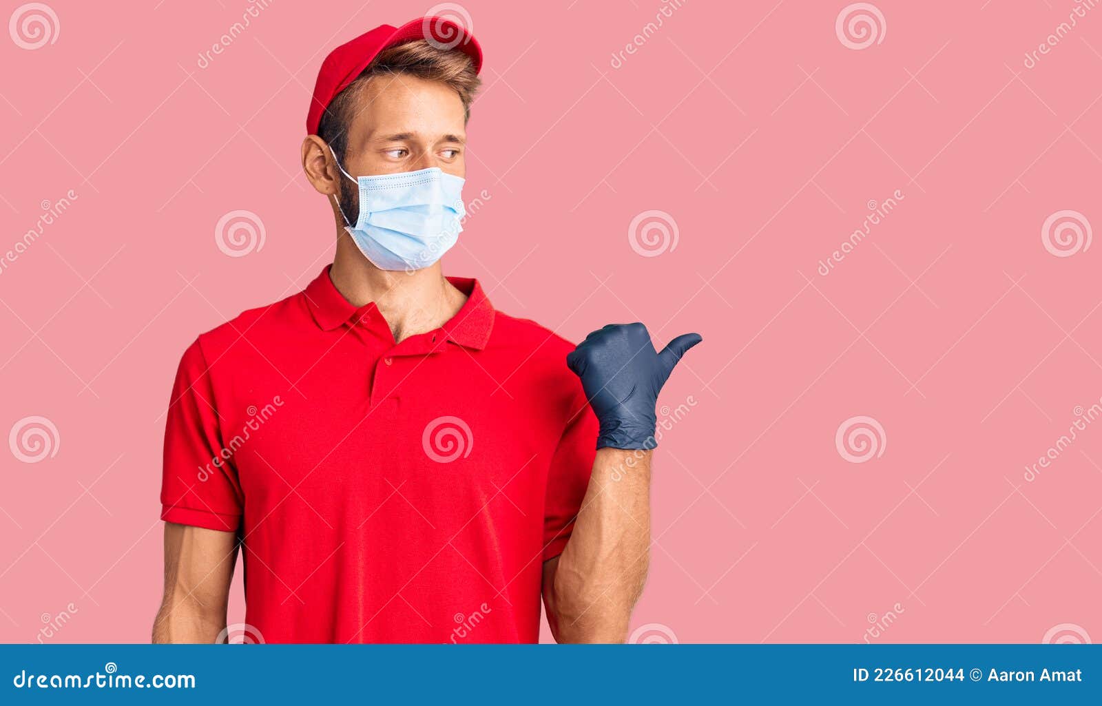 Handsome Blond Man With Beard Wearing Delivery Uniform And Medical Mask