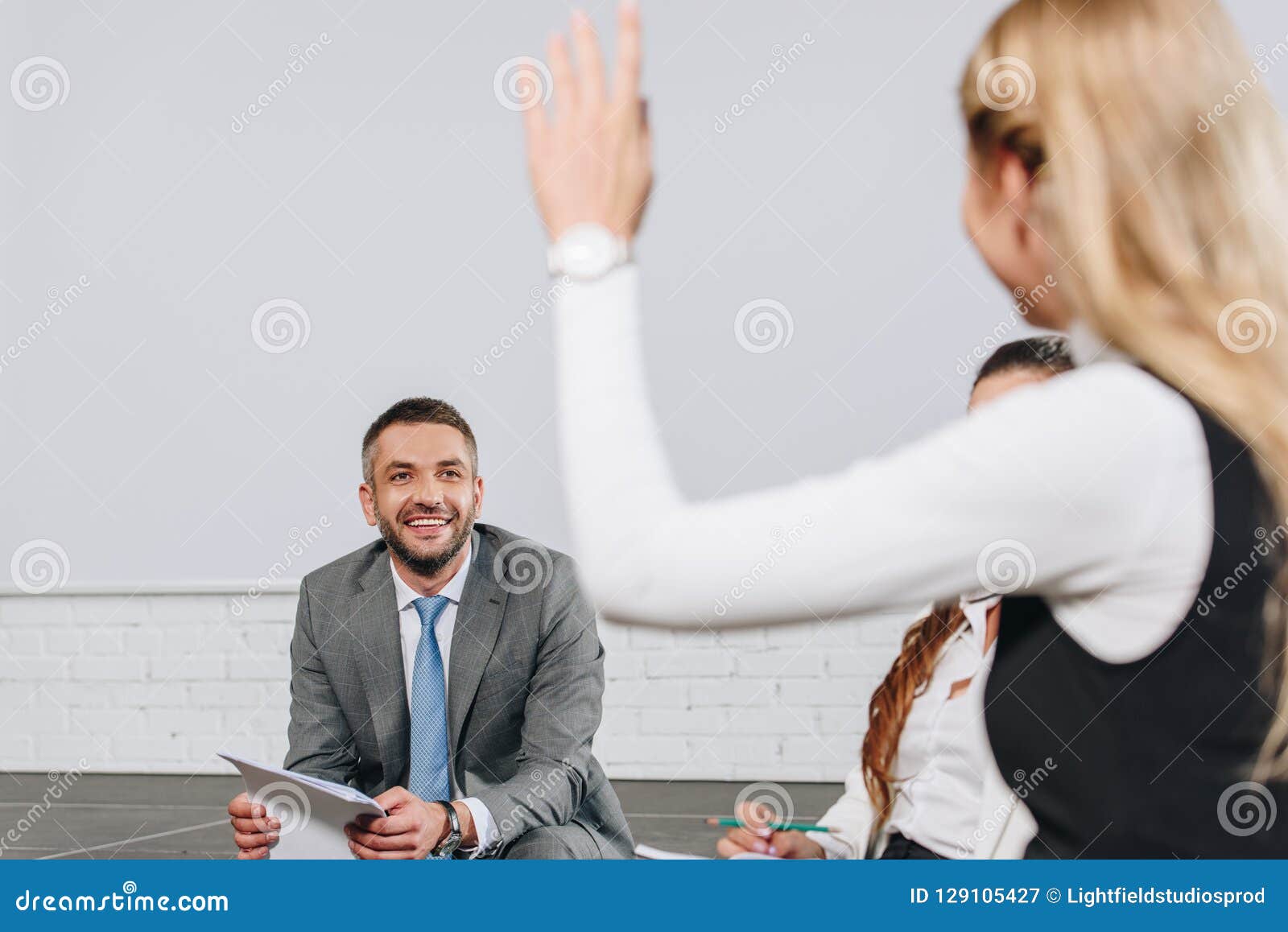 Handsome Business Coach Looking at Participant with Raised Hand during ...