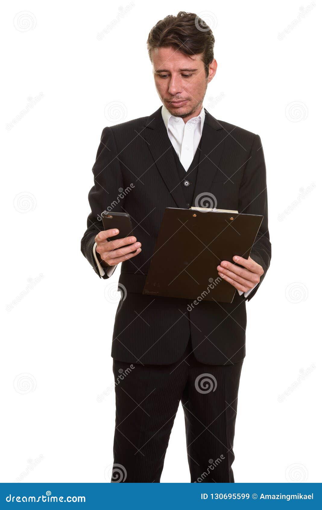 Handsome Caucasian Businessman Using Mobile Phone While Holding Stock