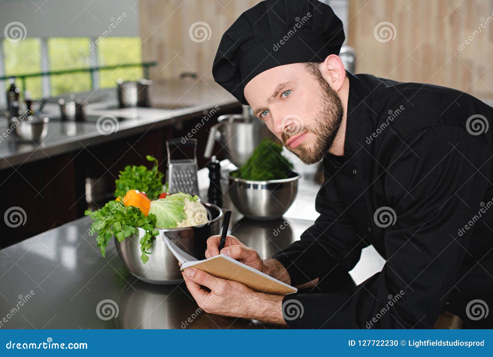 Handsome Chef Writing Down New Recipe To Notebook at Restaurant Kitchen ...