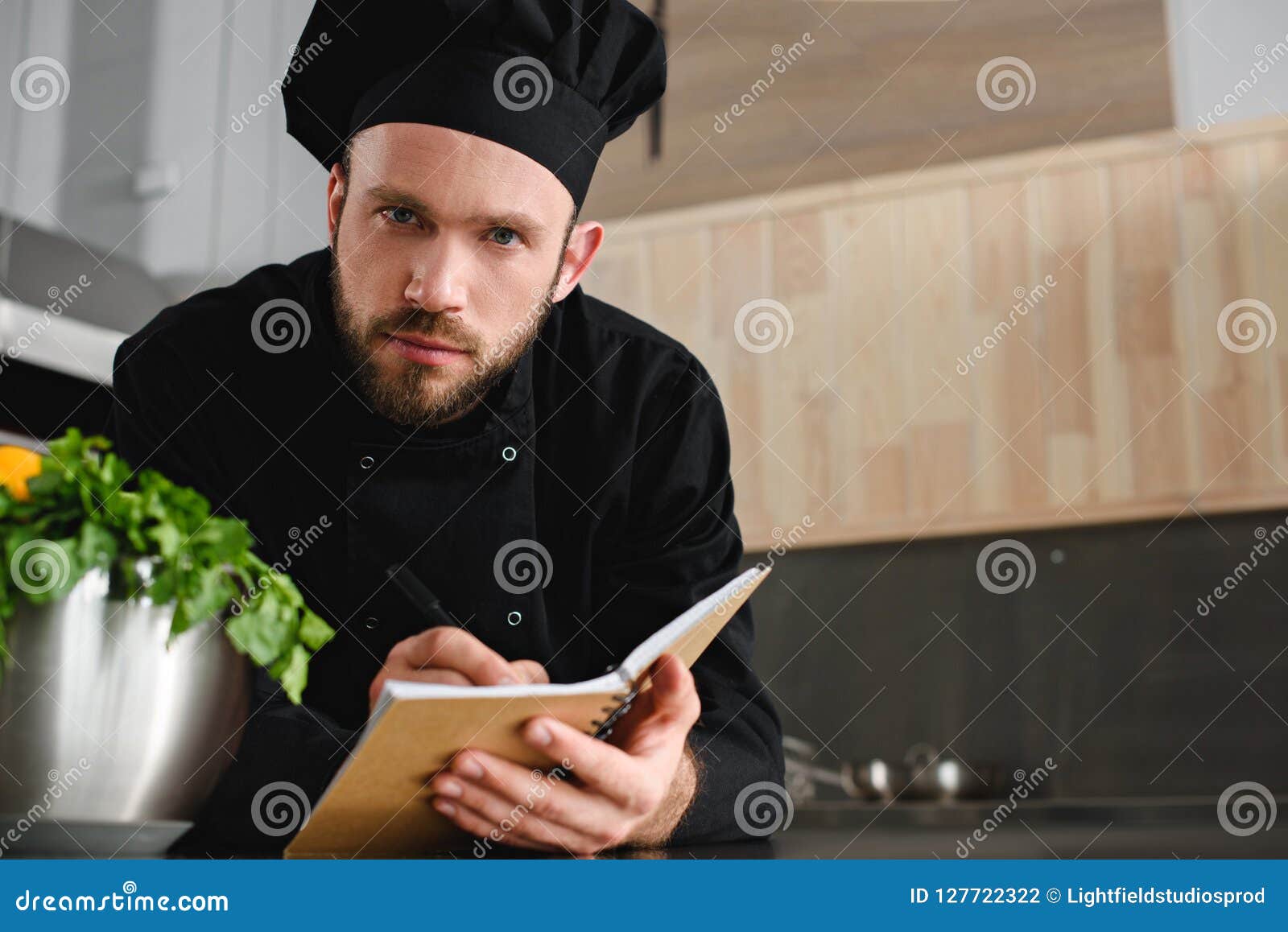 Handsome Chef Writing Down New Recipe To Notebook at Restaurant Kitchen ...