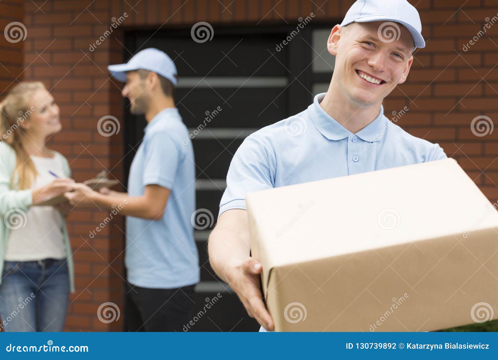 Courier in Blue Uniform Holding Big Brown Package and Smiling Stock ...