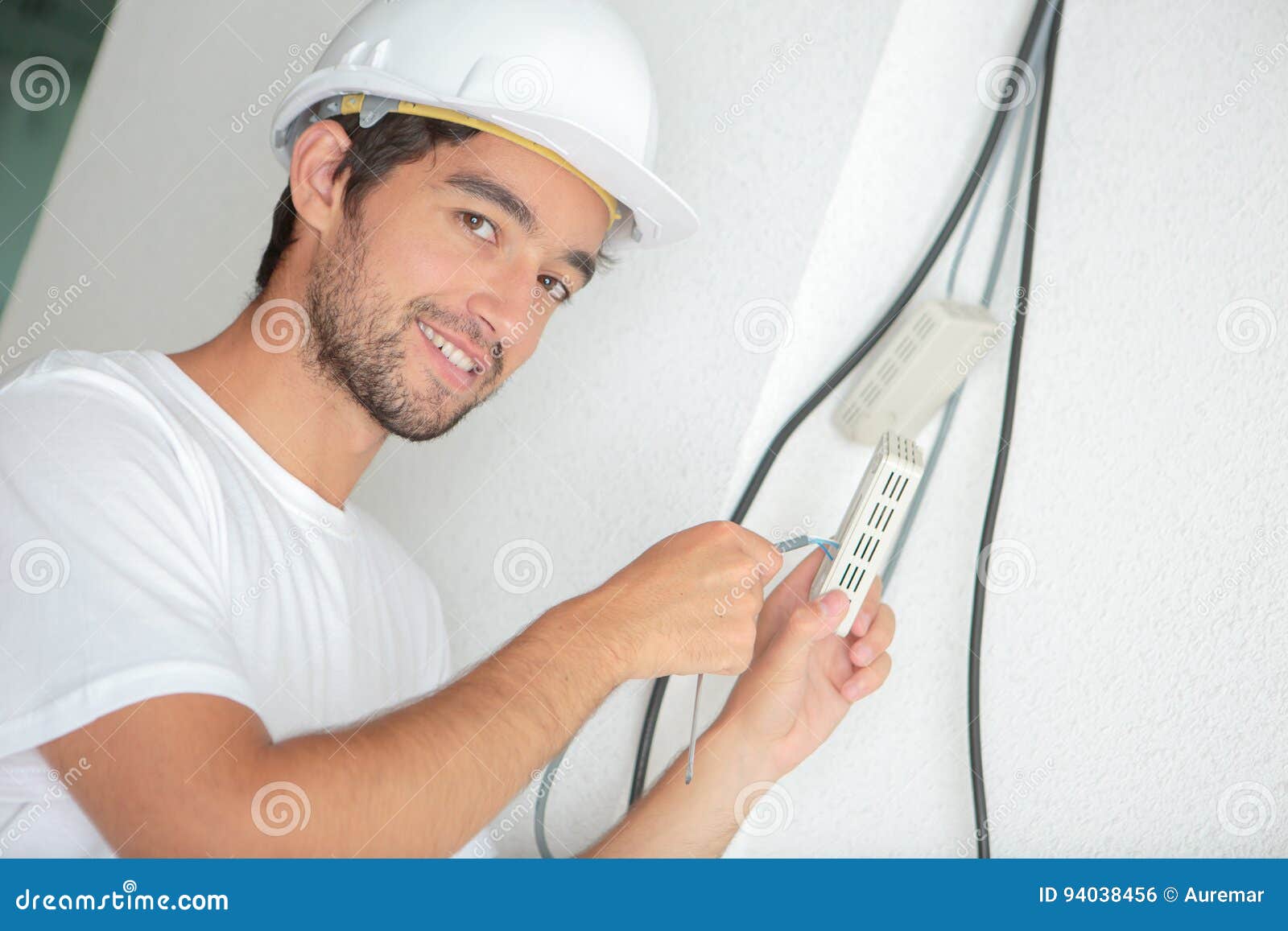 Handsome Electrician Wiring To Wall at Construction Site Stock Photo ...